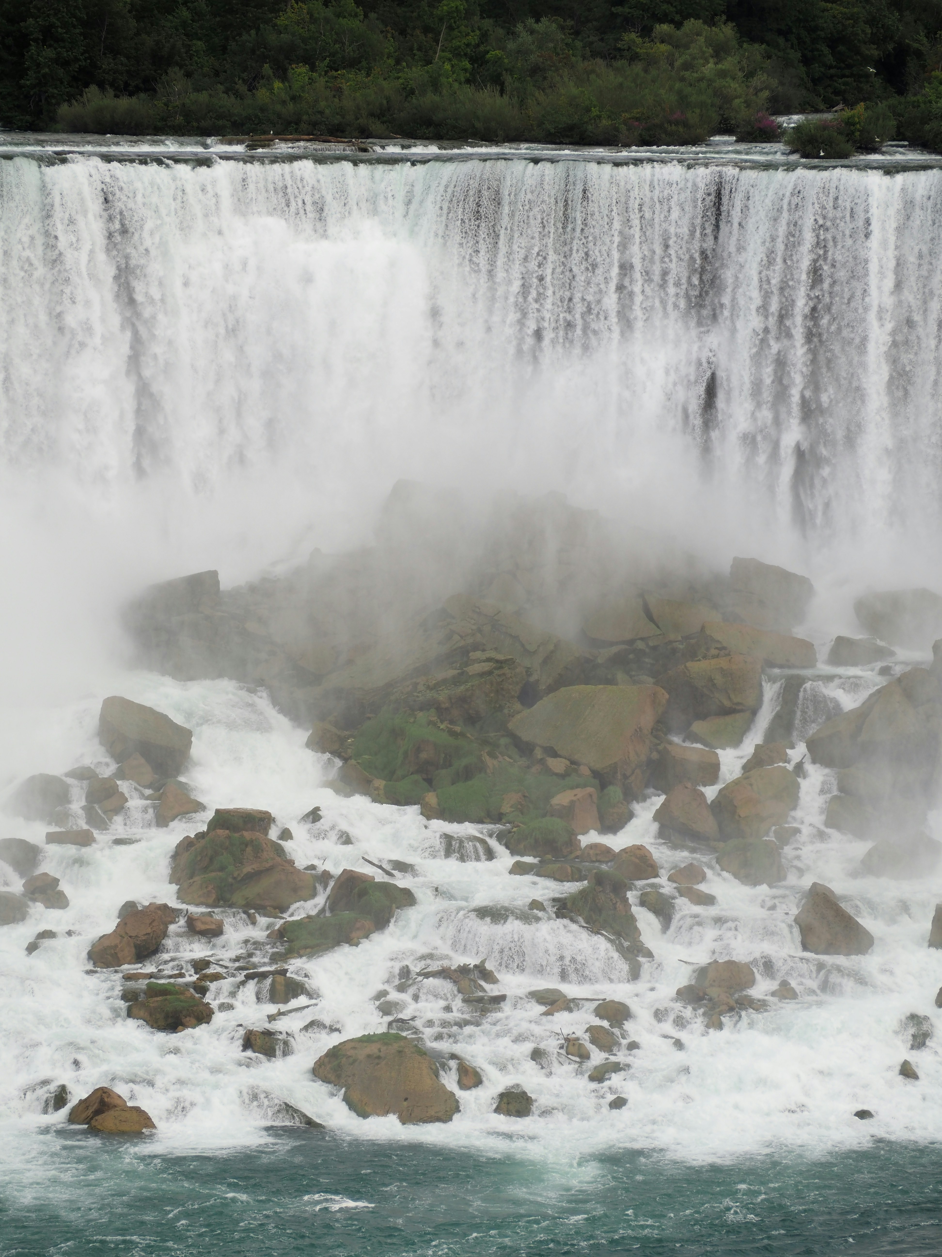 Cascading Curtain: Niagara-like Mist Over Jagged Rocks