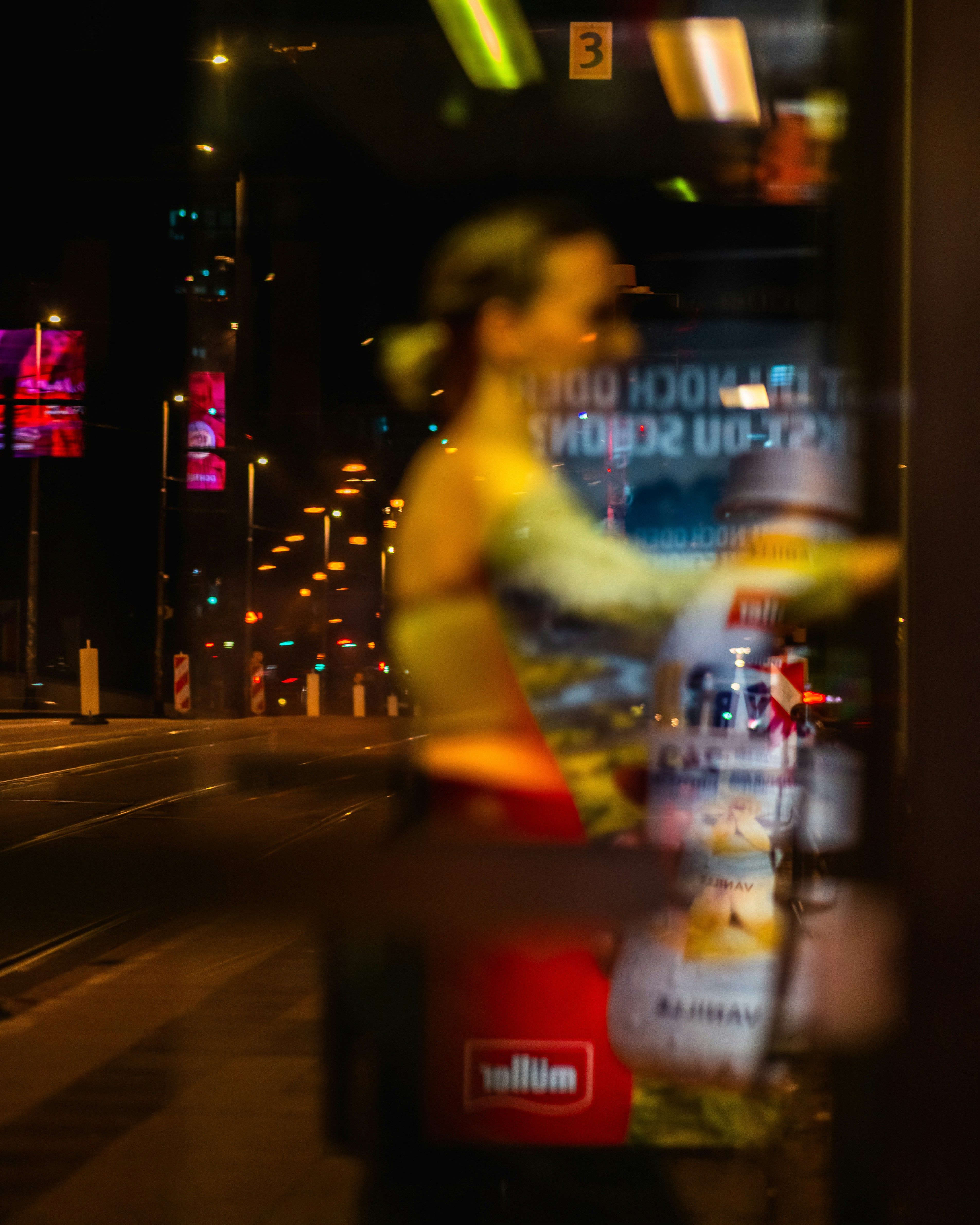 Neon Reflections: Blurred Bus Stop Portrait at Night