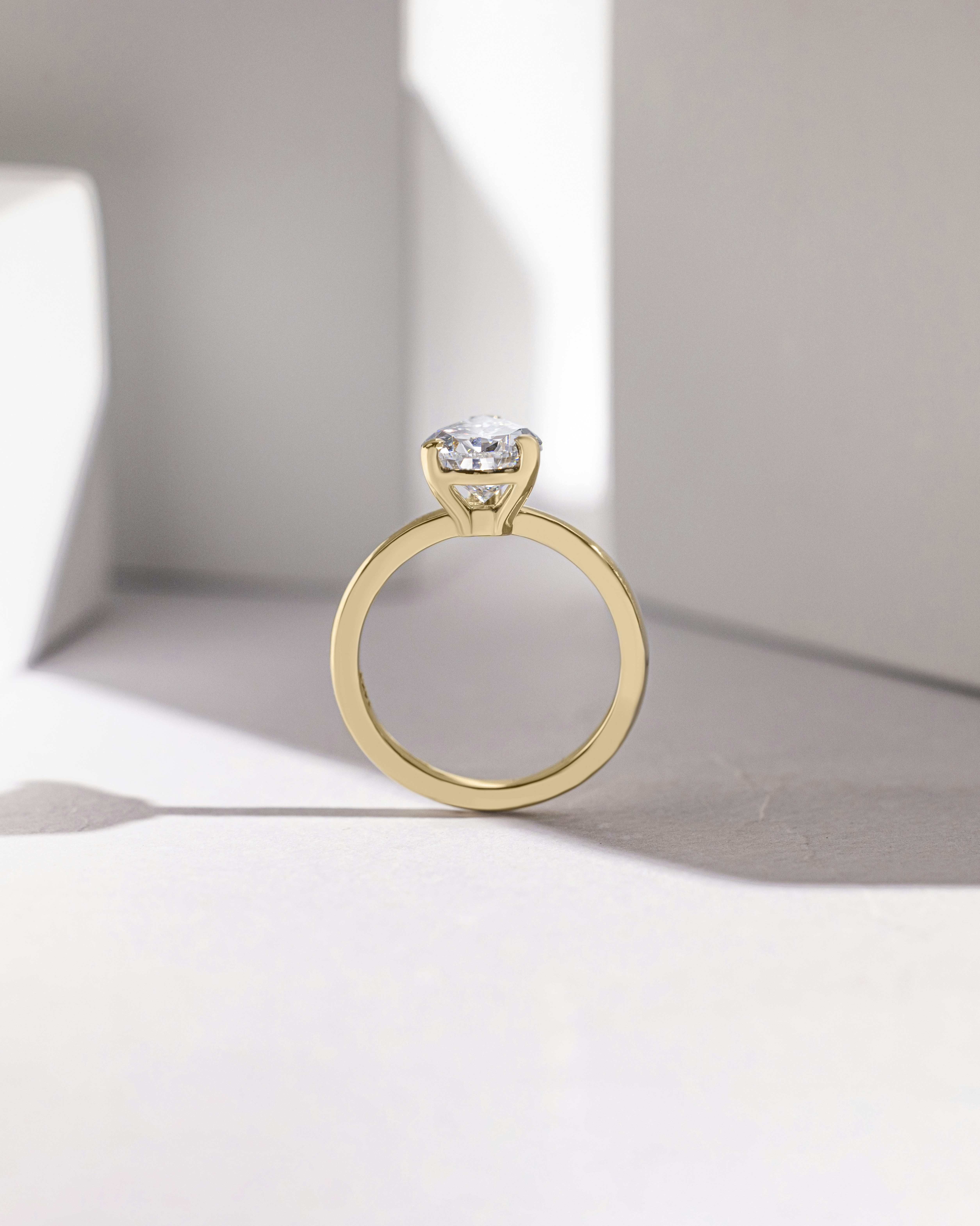 Solitaire in Focus: Minimal gold ring on pale studio backdrop