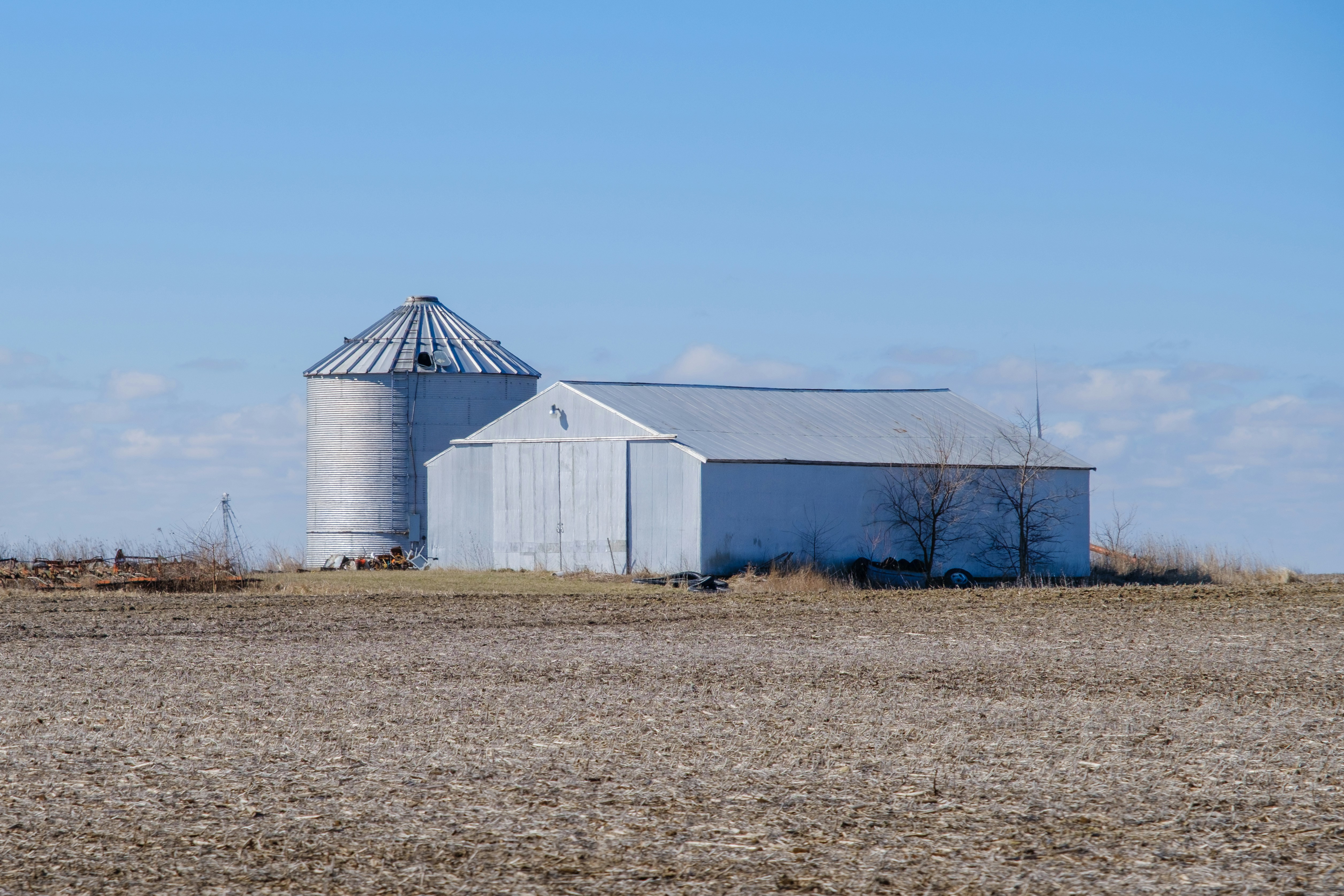 Silo and Farmhouse Under Vast Prairie Sky