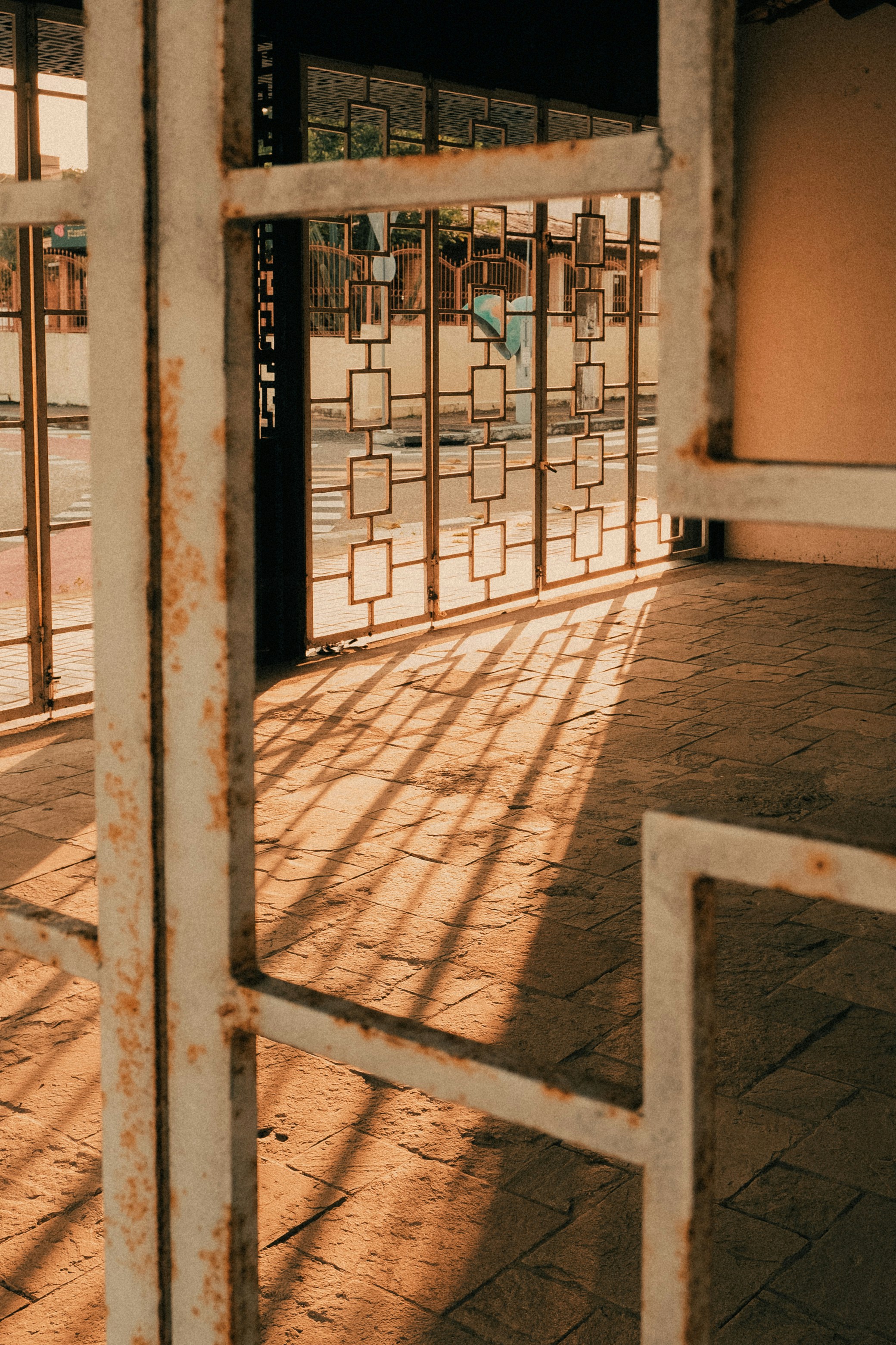  geometric shadows: rusted bars and warm light color the courtyard