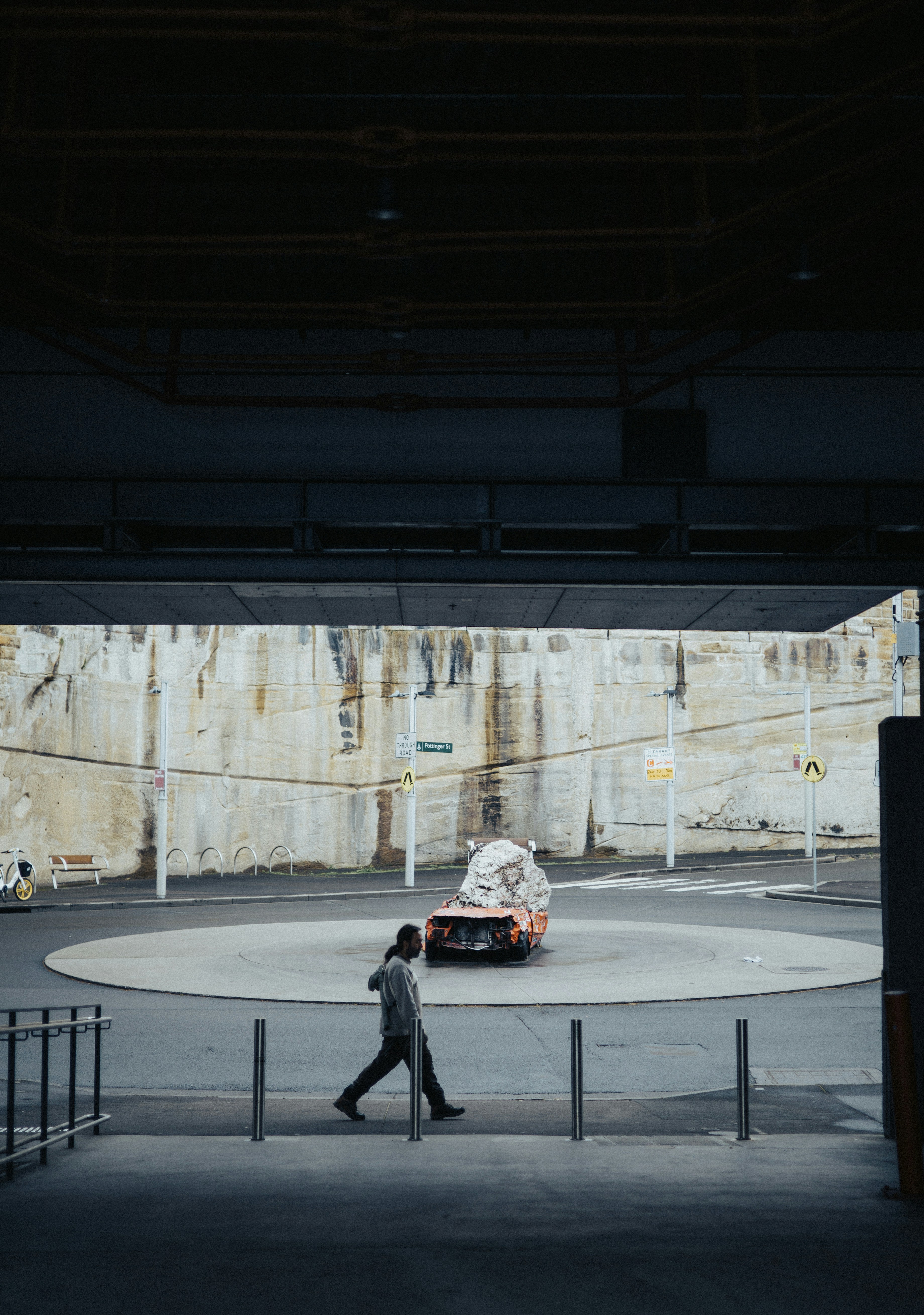 Underpass Observatory: A Pedestrian, A Carved Rock, A Circular Roundabout