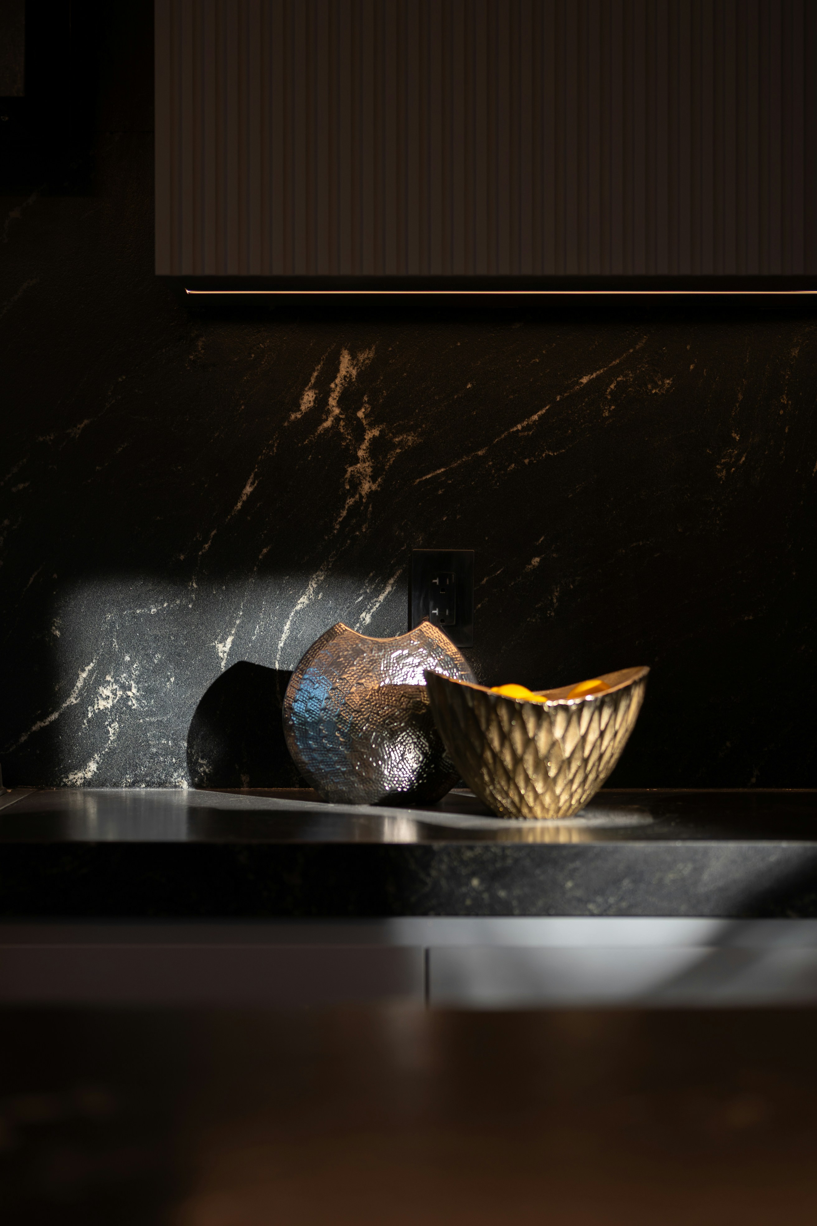 Clay vases on a marble kitchen counter glow in low evening light