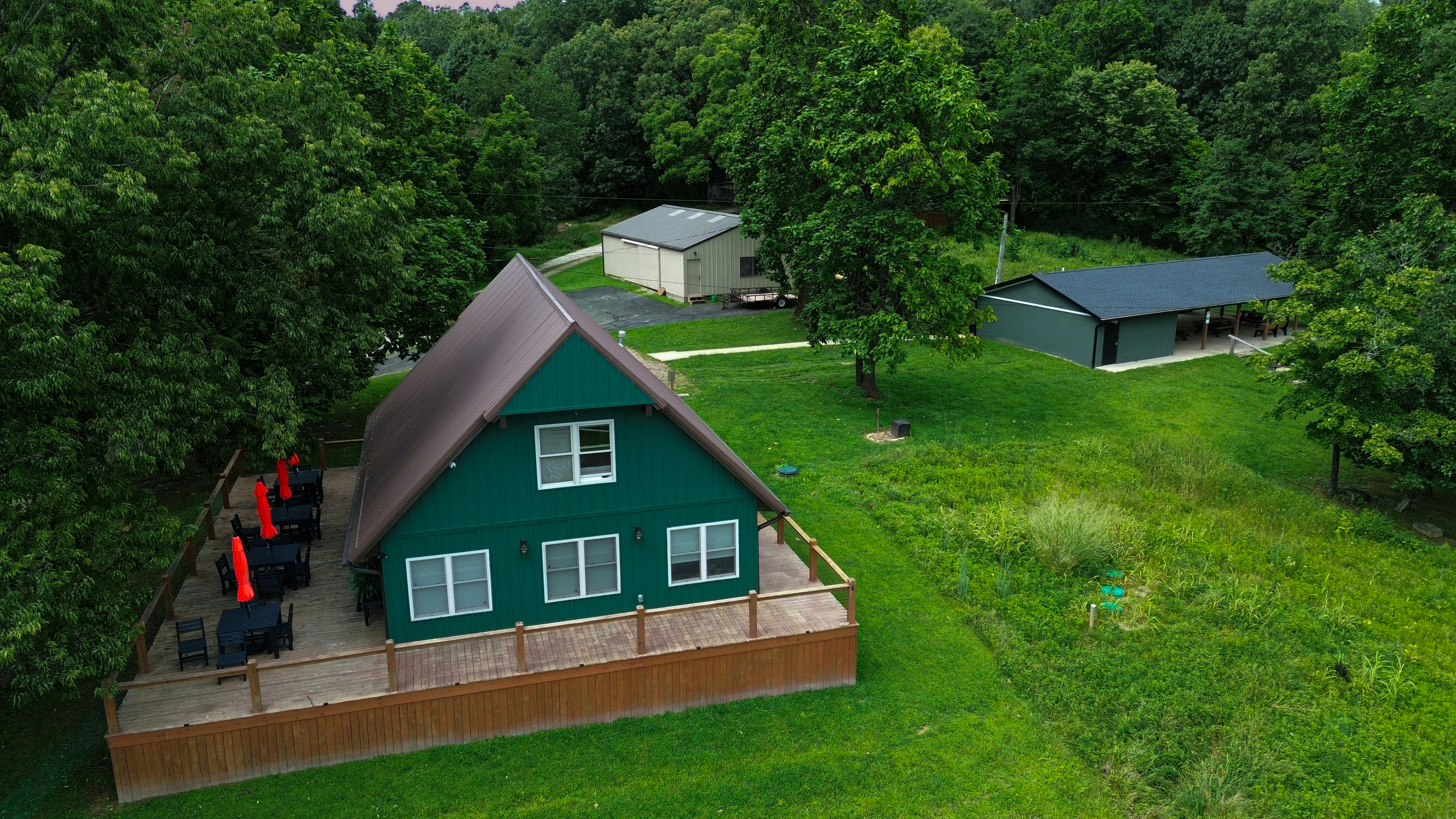 A Quiet Green Retreat: Aerial View of a Green House Amid Mature Trees