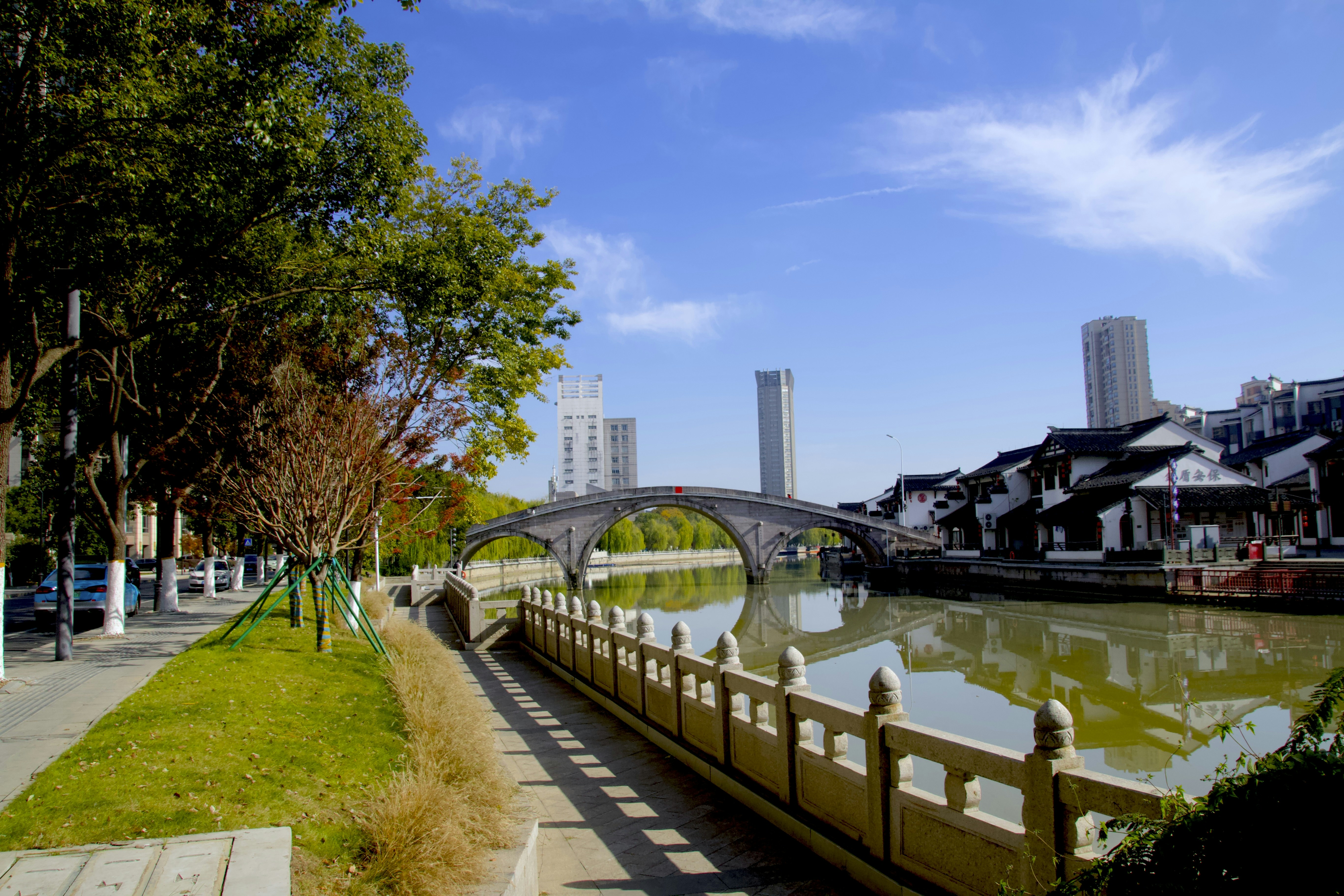 Bridge and Riverside Walkway Framed by Urban Skyline