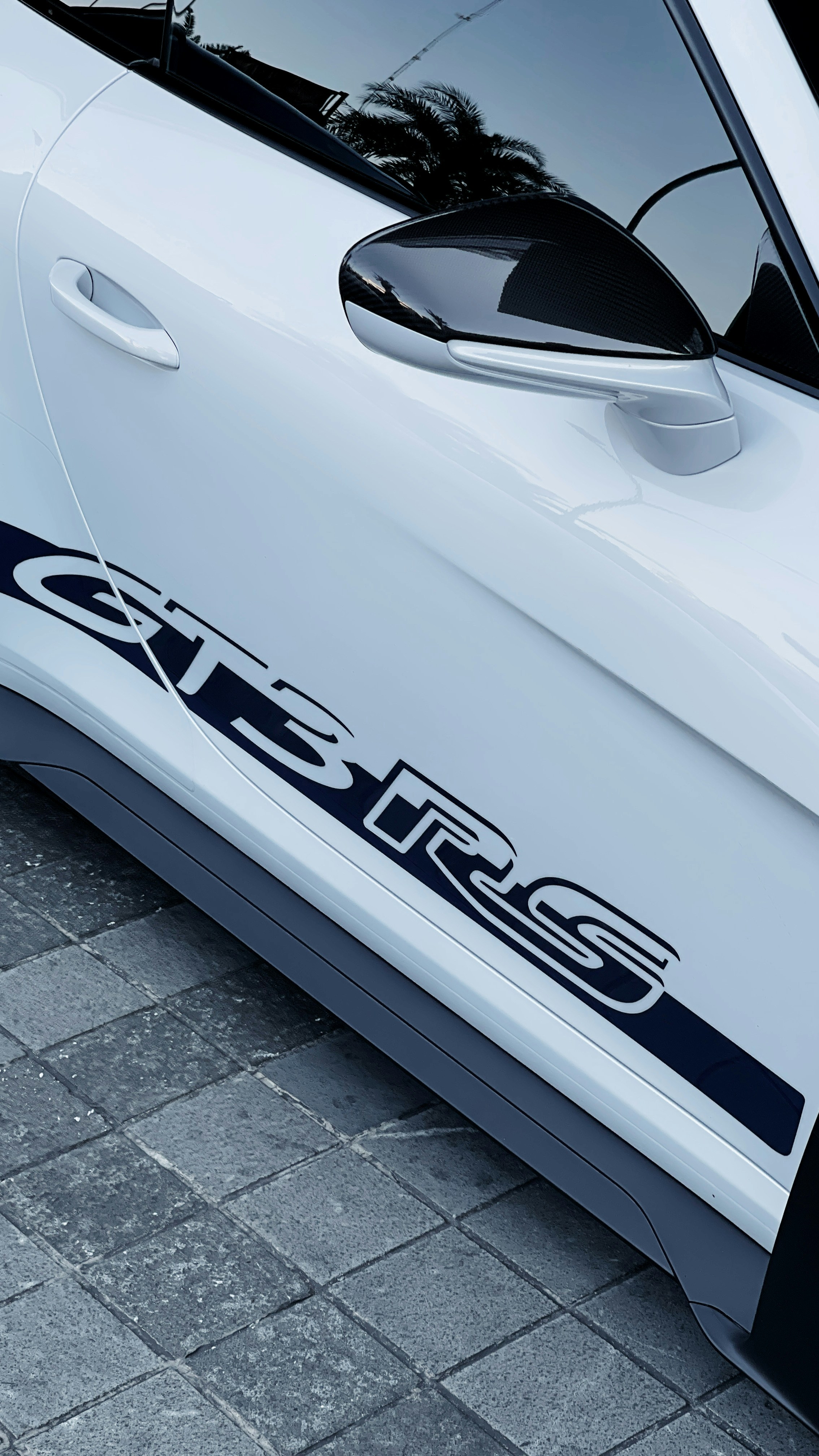 High-contrast side view of a white police car door with GT3RS-style branding