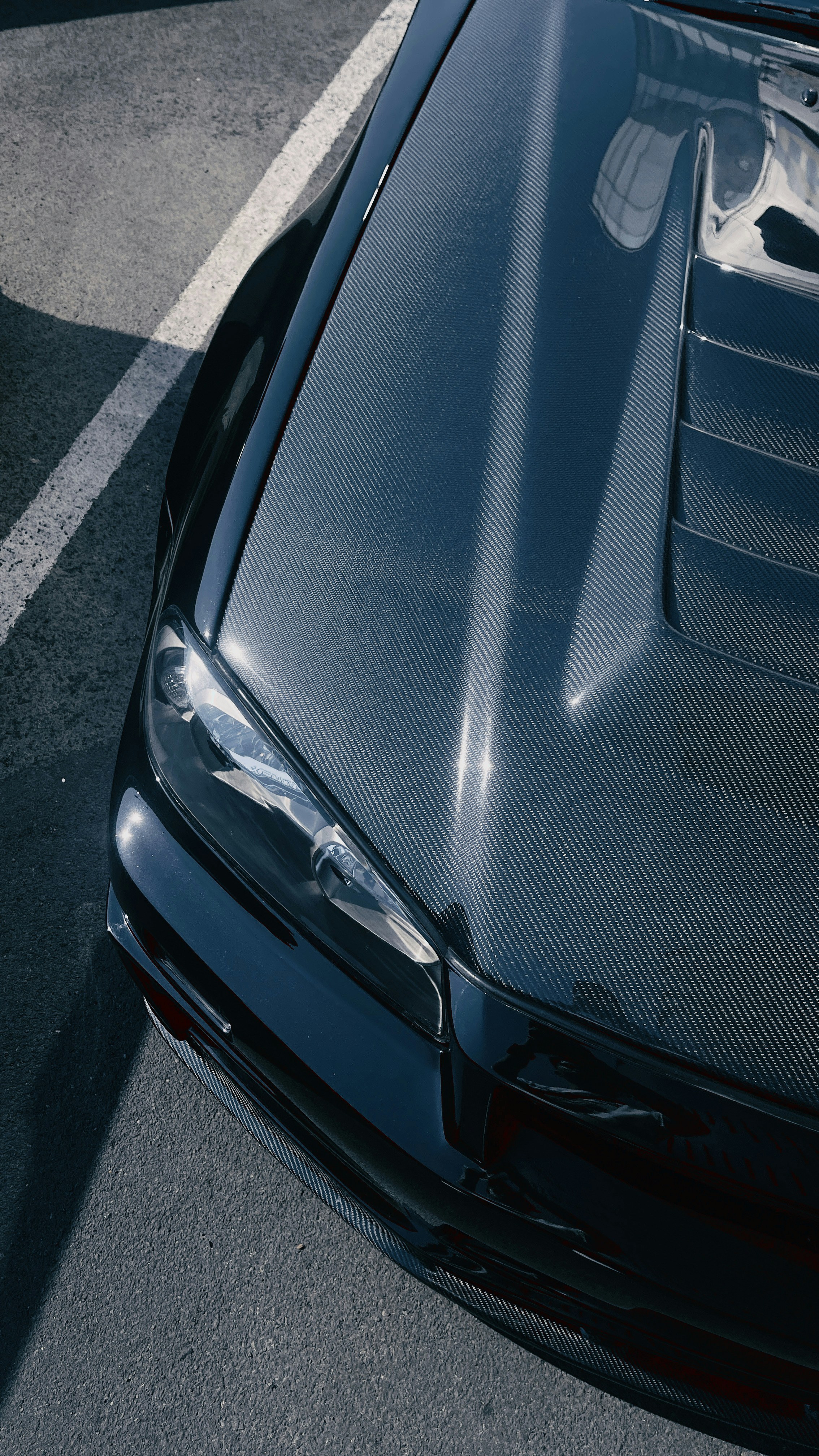 Carbon skin and Chrome Edge: A close-up of a carbon-fiber hood and headlight