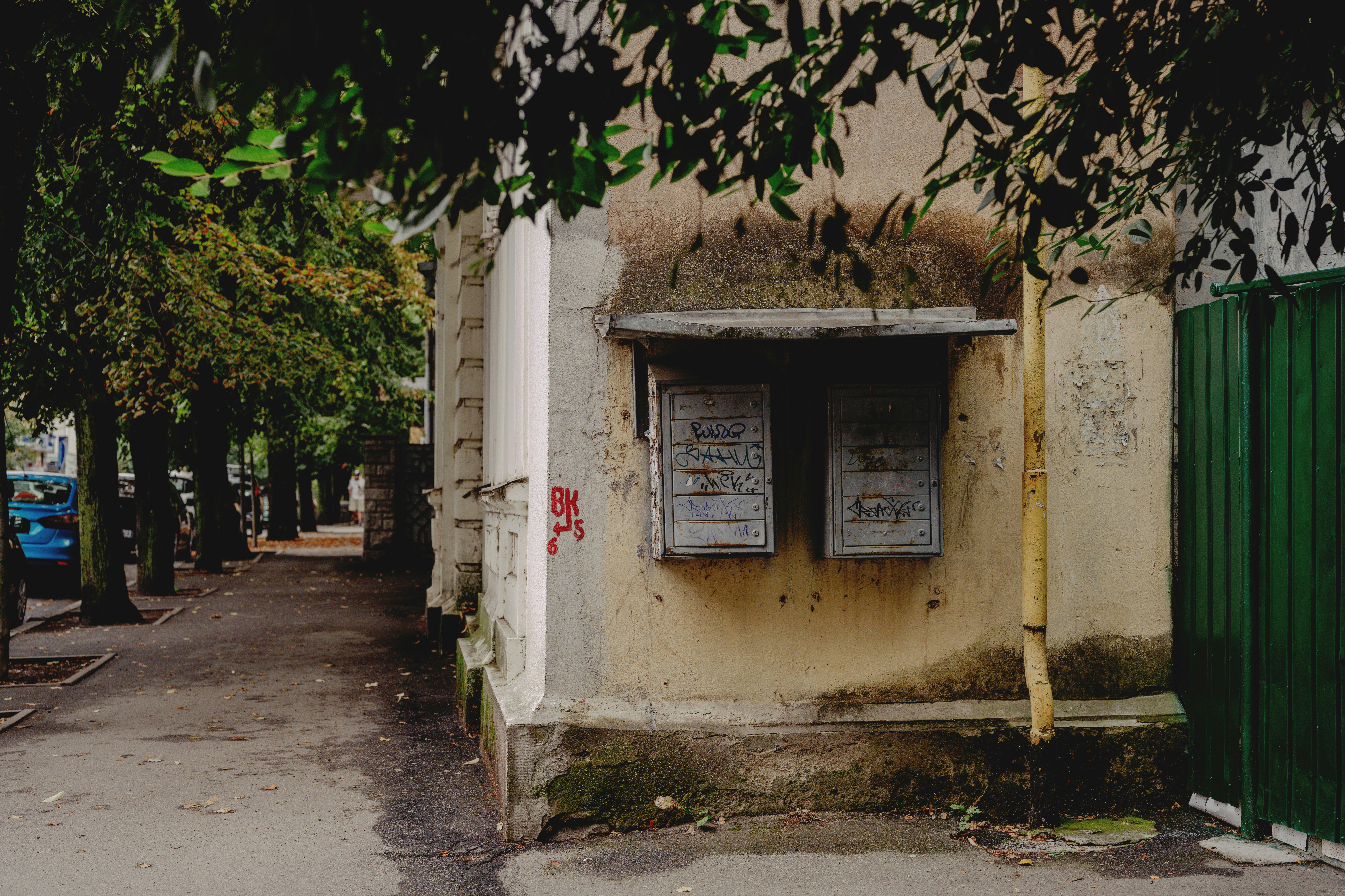 Weathered Utility Wall with Mailboxes Framing a Quiet Street
