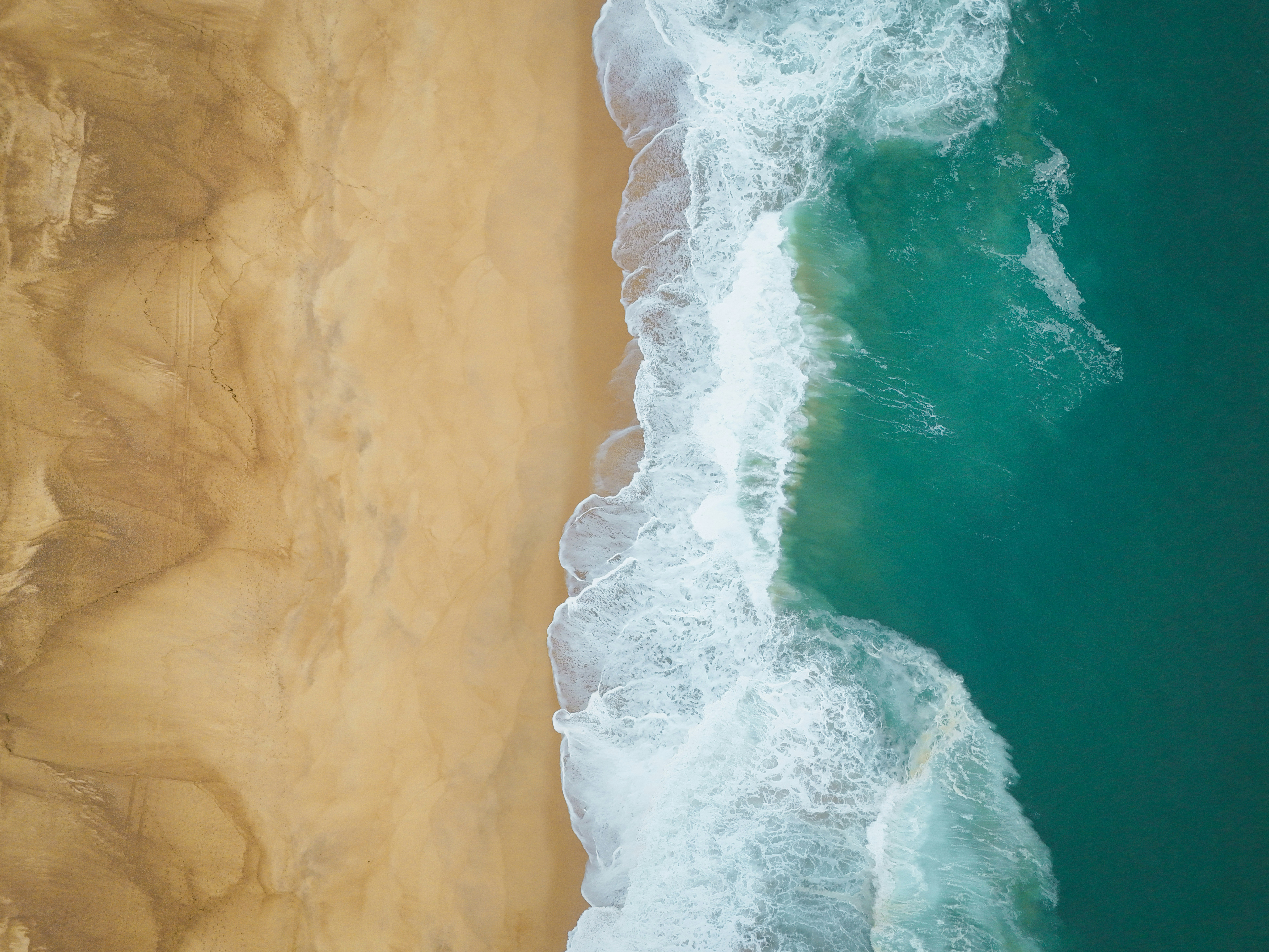 Coastline Divide: Aerial Contrast Between Sand and Sea