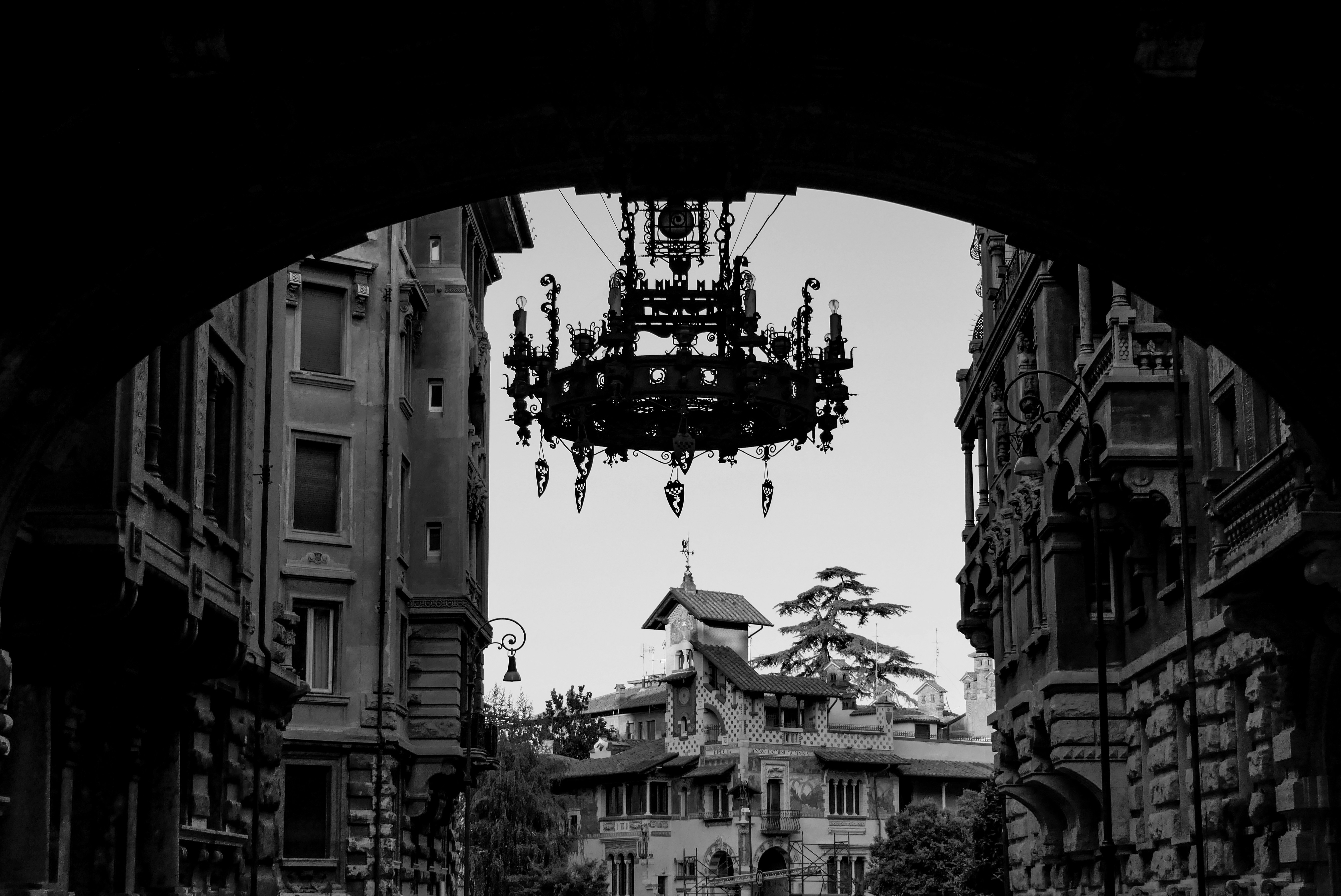 Archway of Darkness: A Grand Arcaded View Framing a Dramatic Chandelier