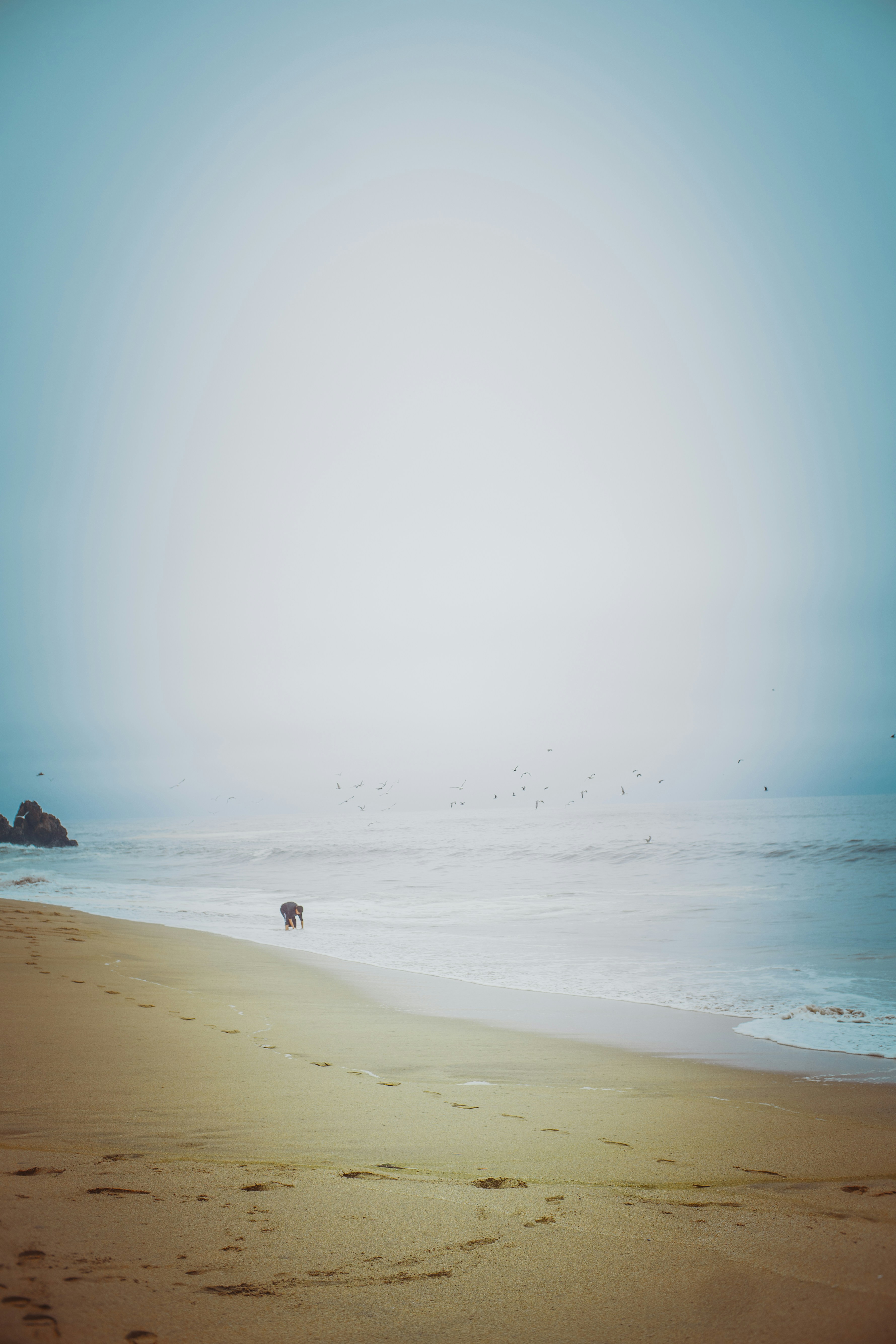 Solitary Beach Wanderer Under a Soft Horizon
