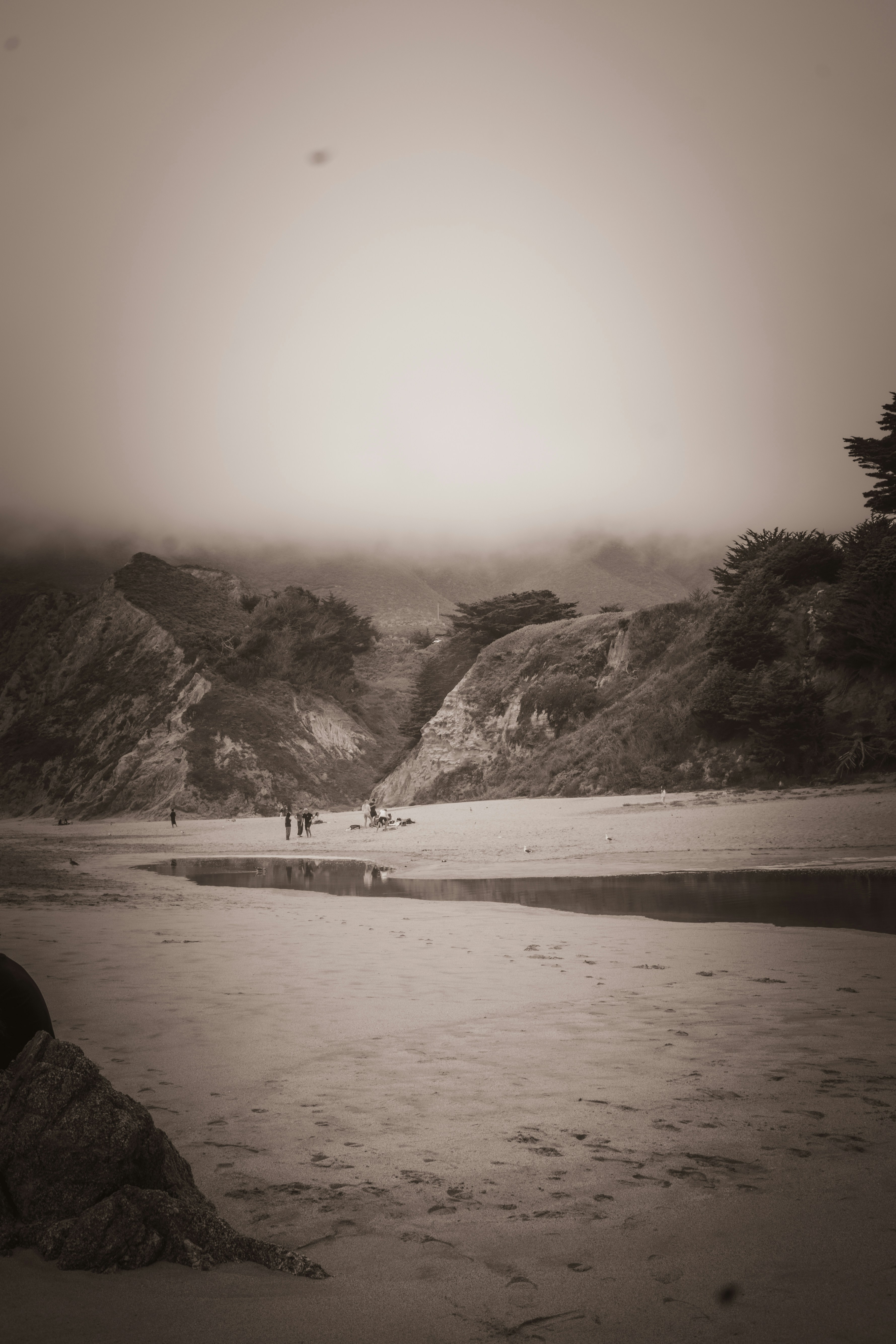 Quiet Shoreline at Dusk with Fog over Cliffs