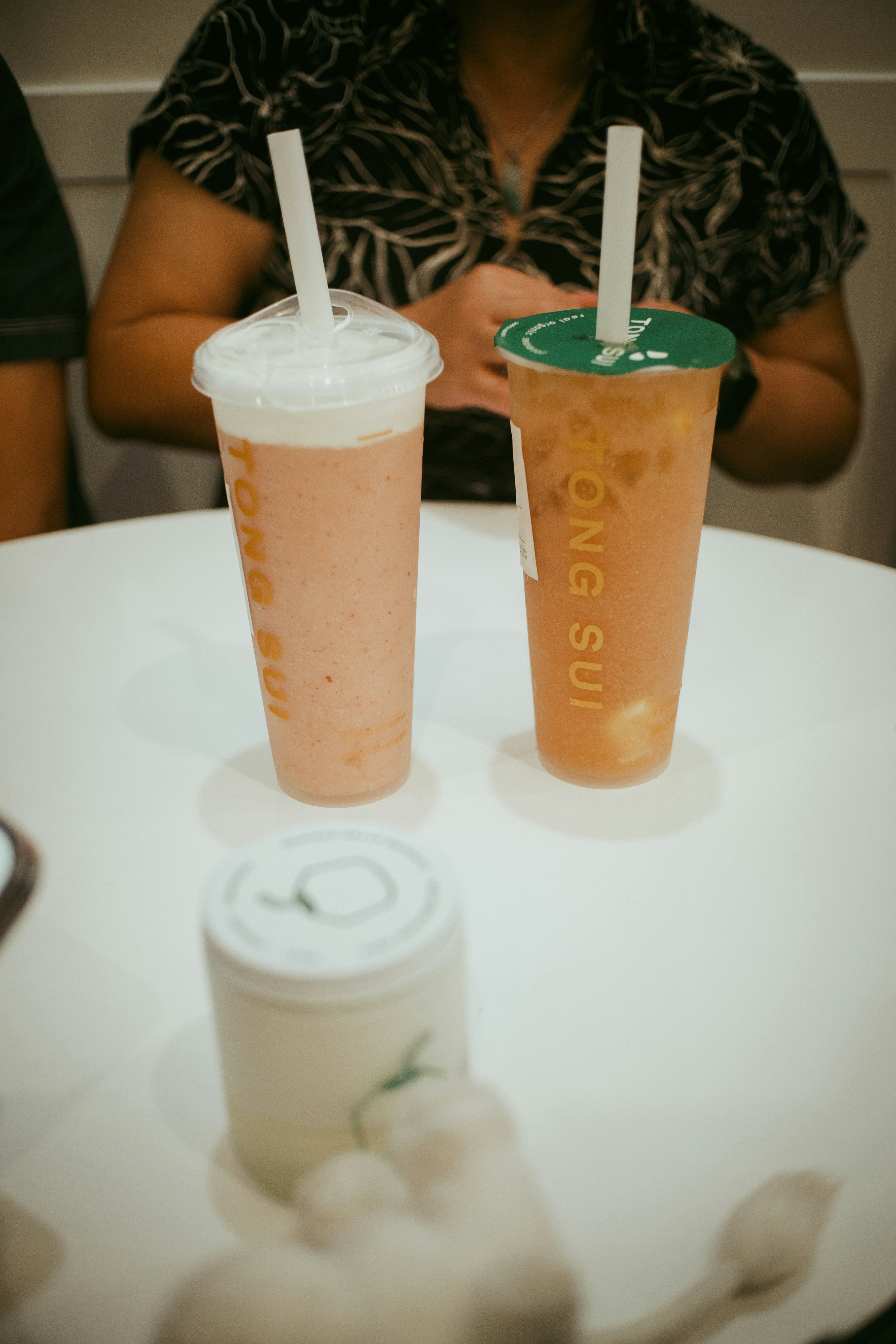 Two Milkshakes on a Bright White Table in a Café