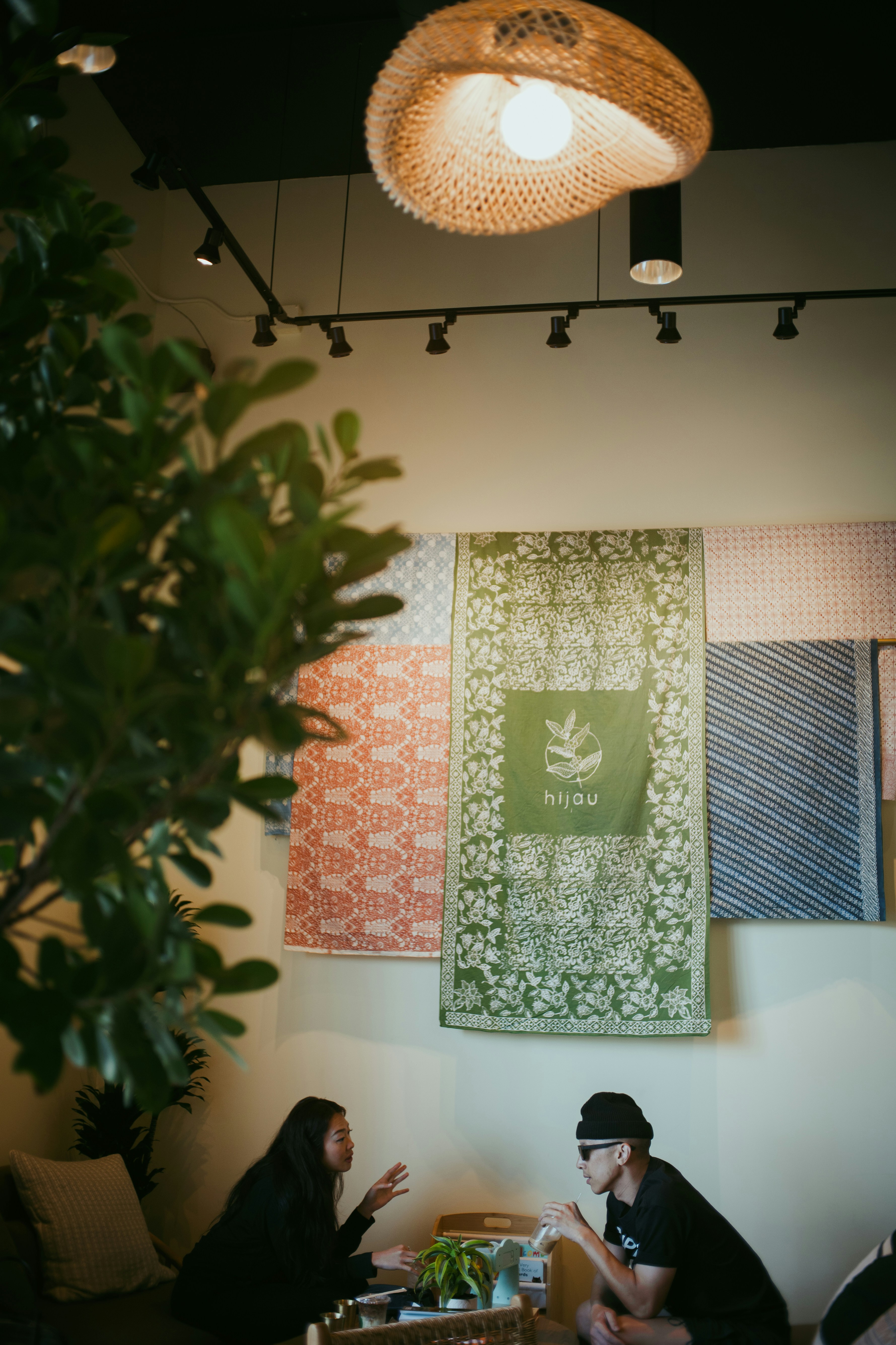 Conversations under a woven glow: cafe scene framed by patterned textiles