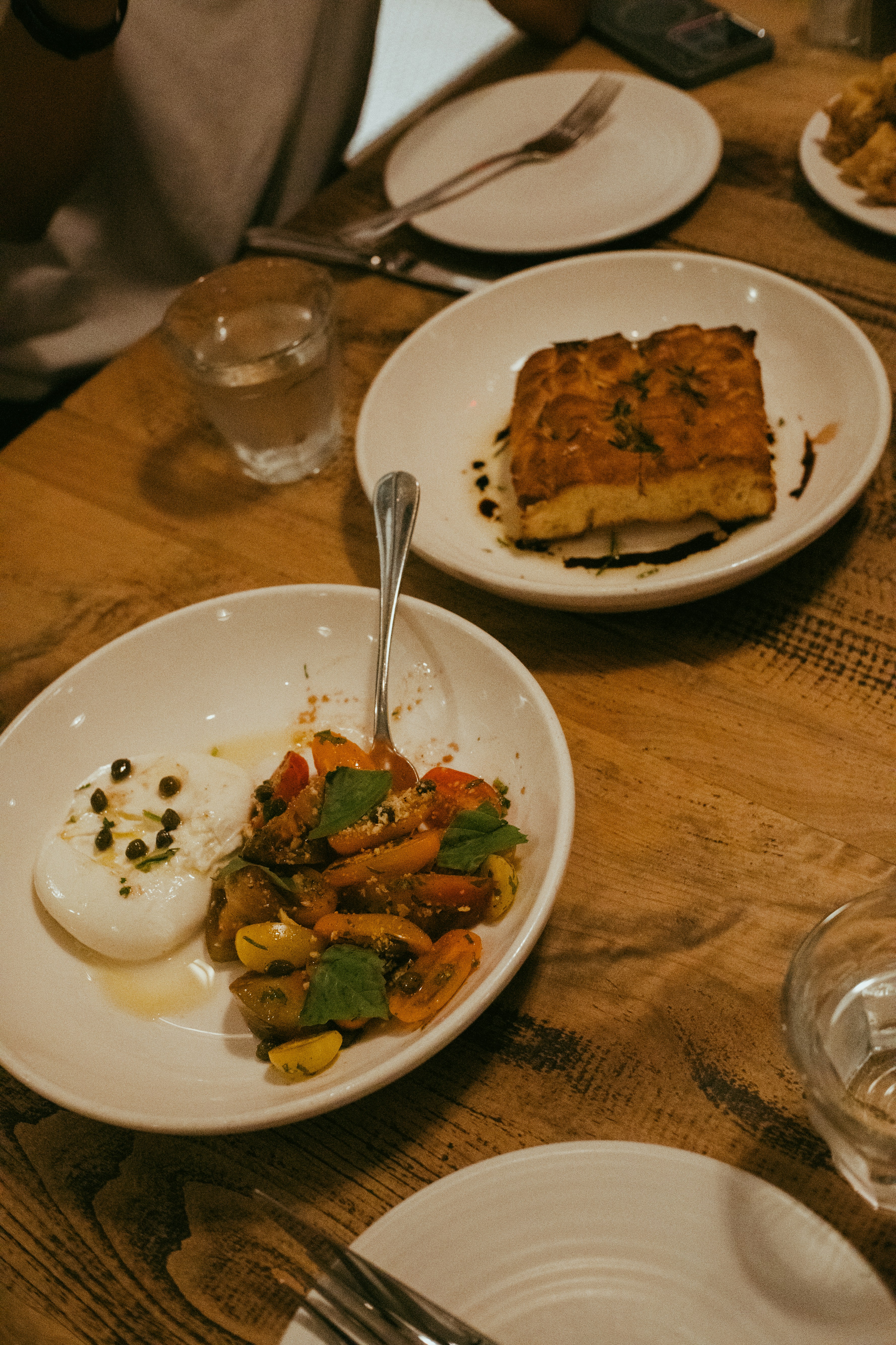 Herb-crusted pastry and a colorful ratatouille await at a rustic wooden table