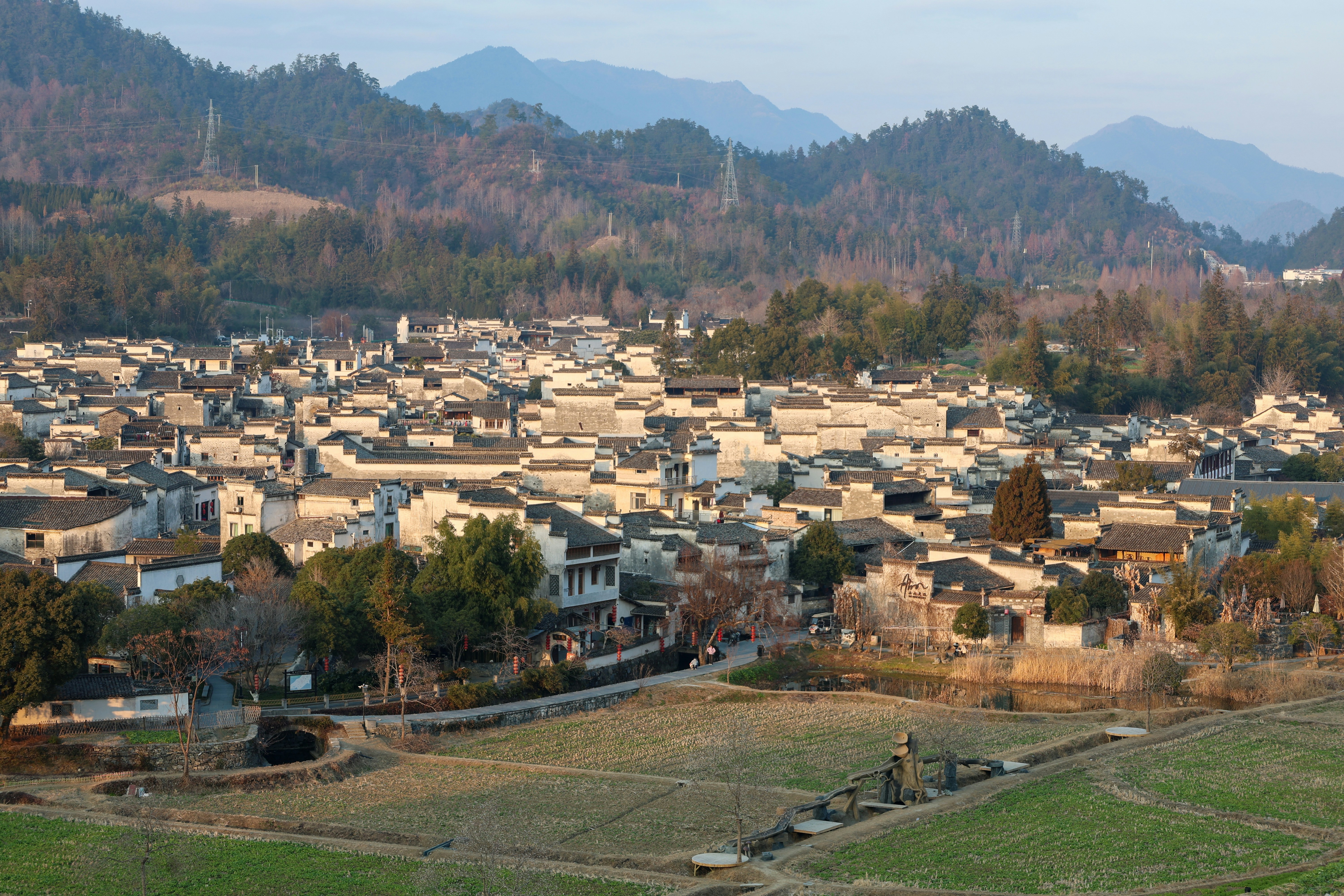 Sunlit hillside village: terraced roofs under a distant ridge