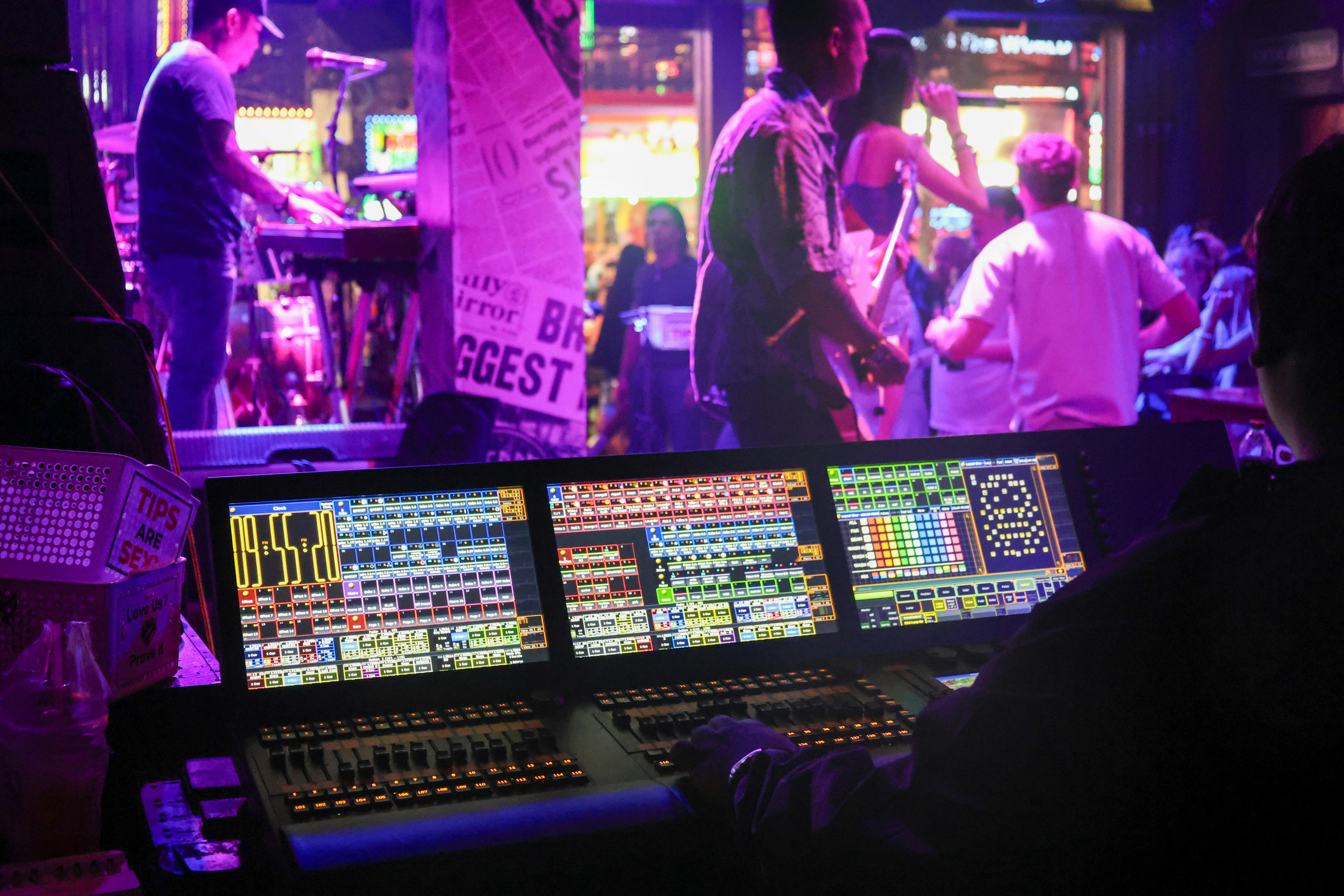 Lost in the Mix: Live Console Lights Amid Neon Clubgoers