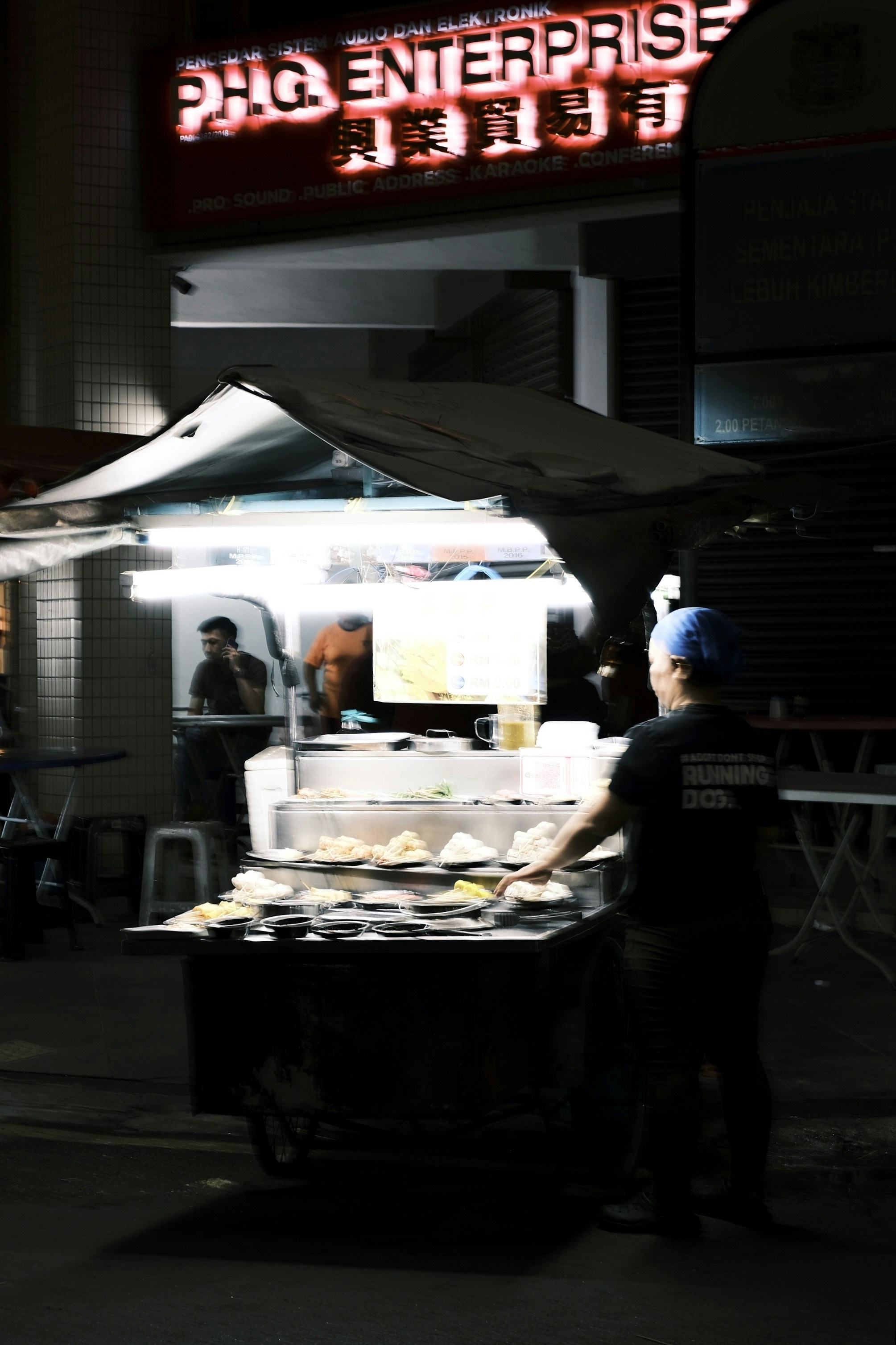 Night Market Grill: Street Vendor Under Neon Sign