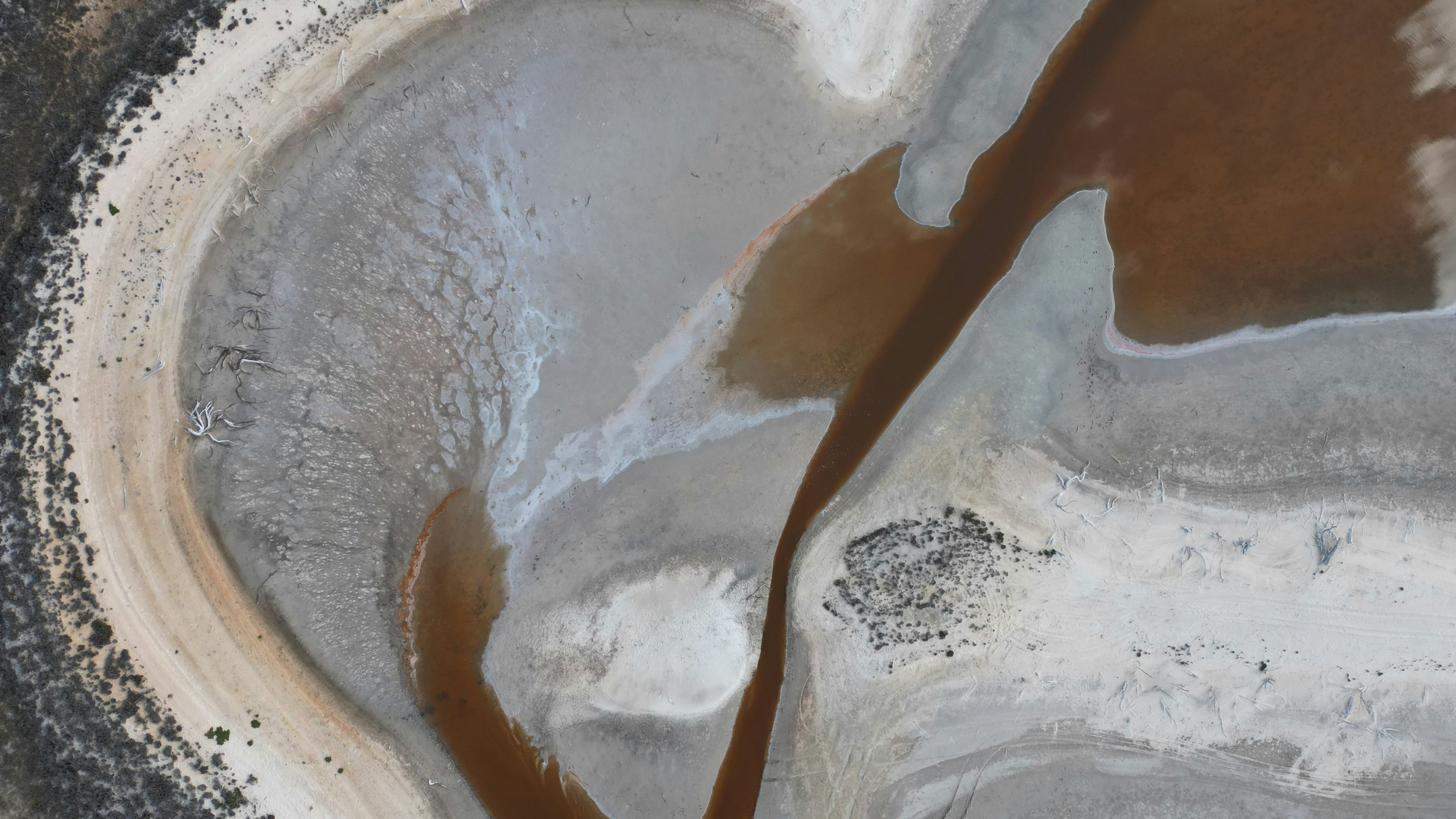 Limestone meander: an aerial study of mineral tides and salt-stained curves