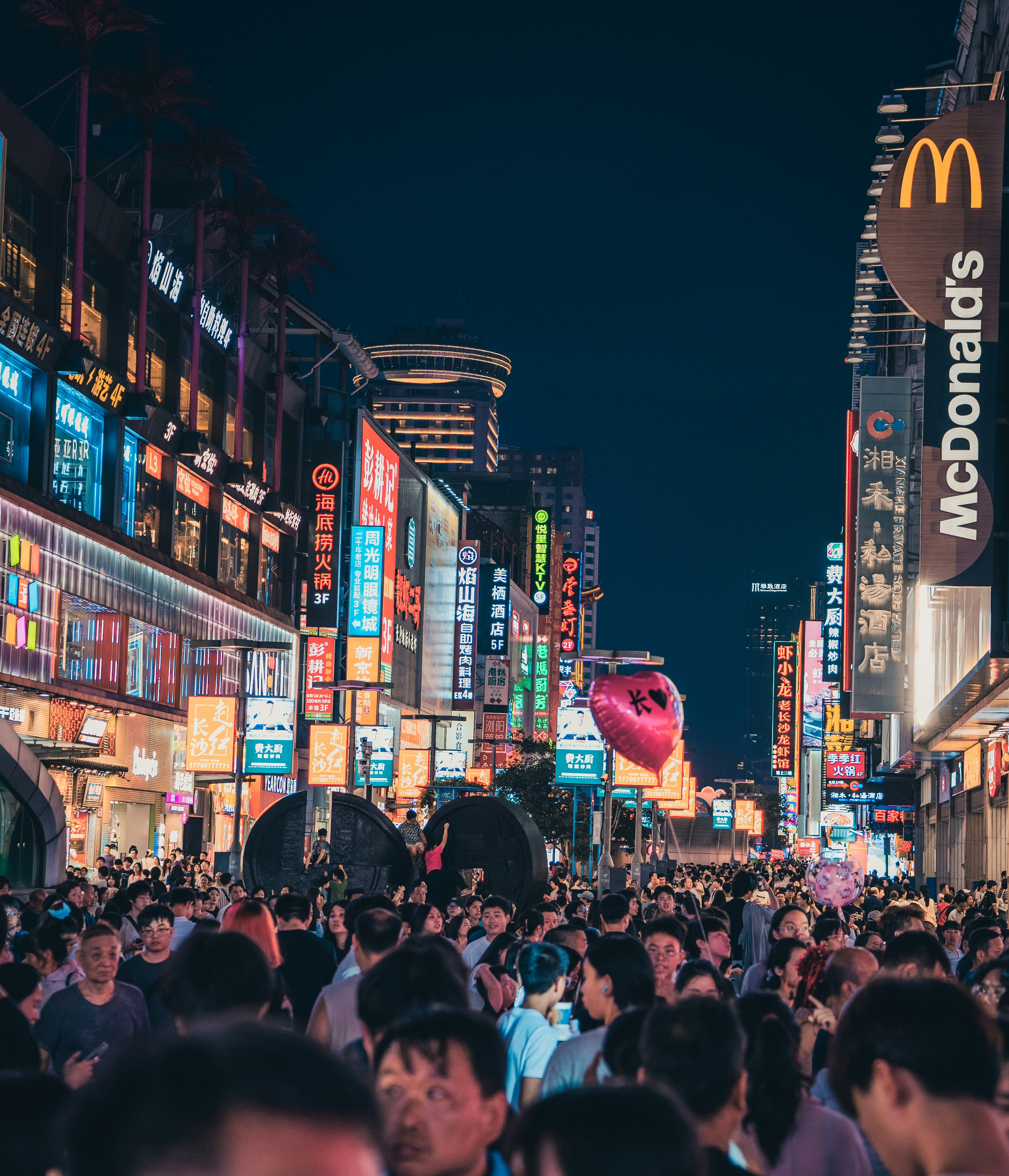 Neon Pulse: Crowded Night Street Speckled with Giant Brand Signs
