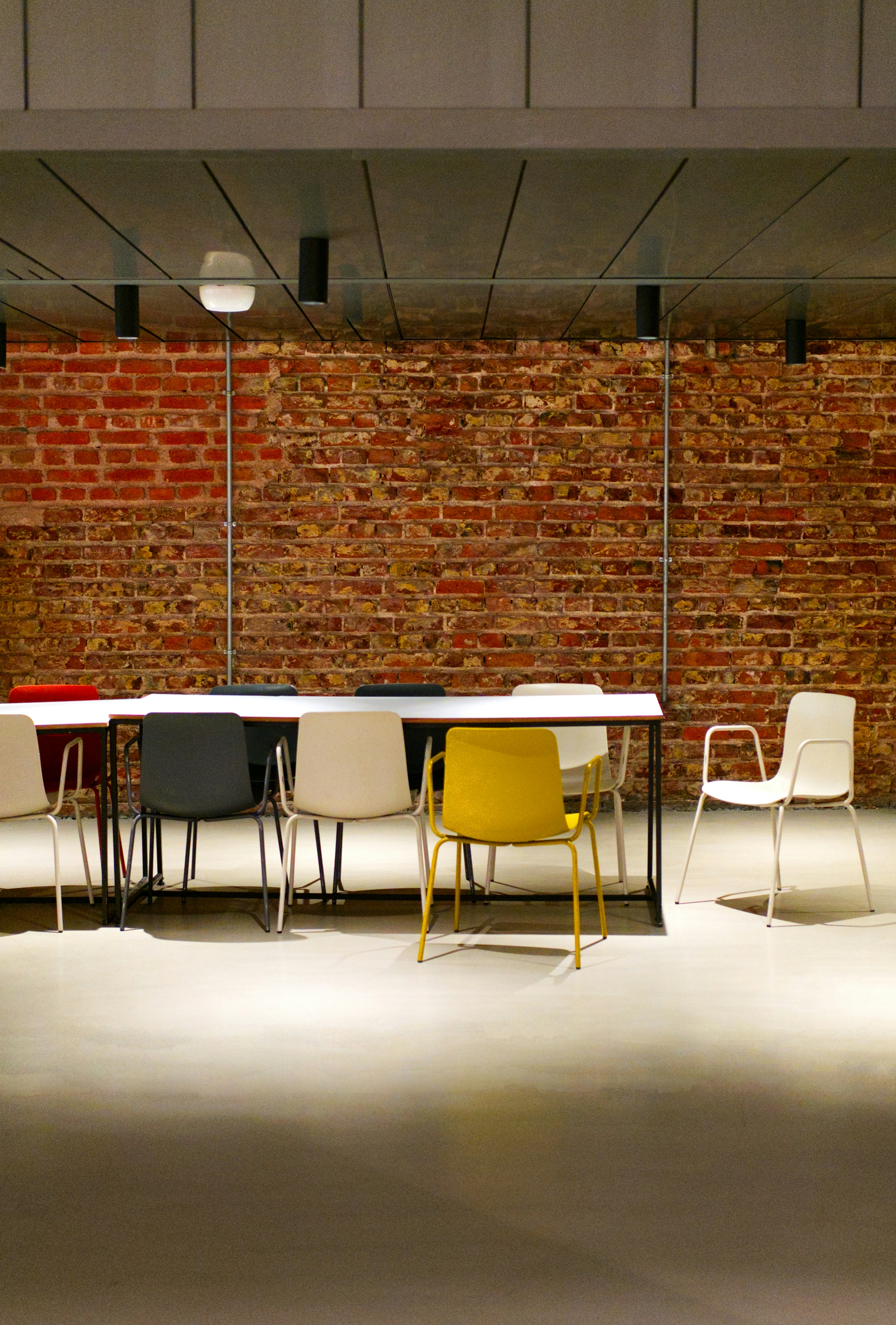 Colorful Chairs Across a Brick-Walled Meeting Space