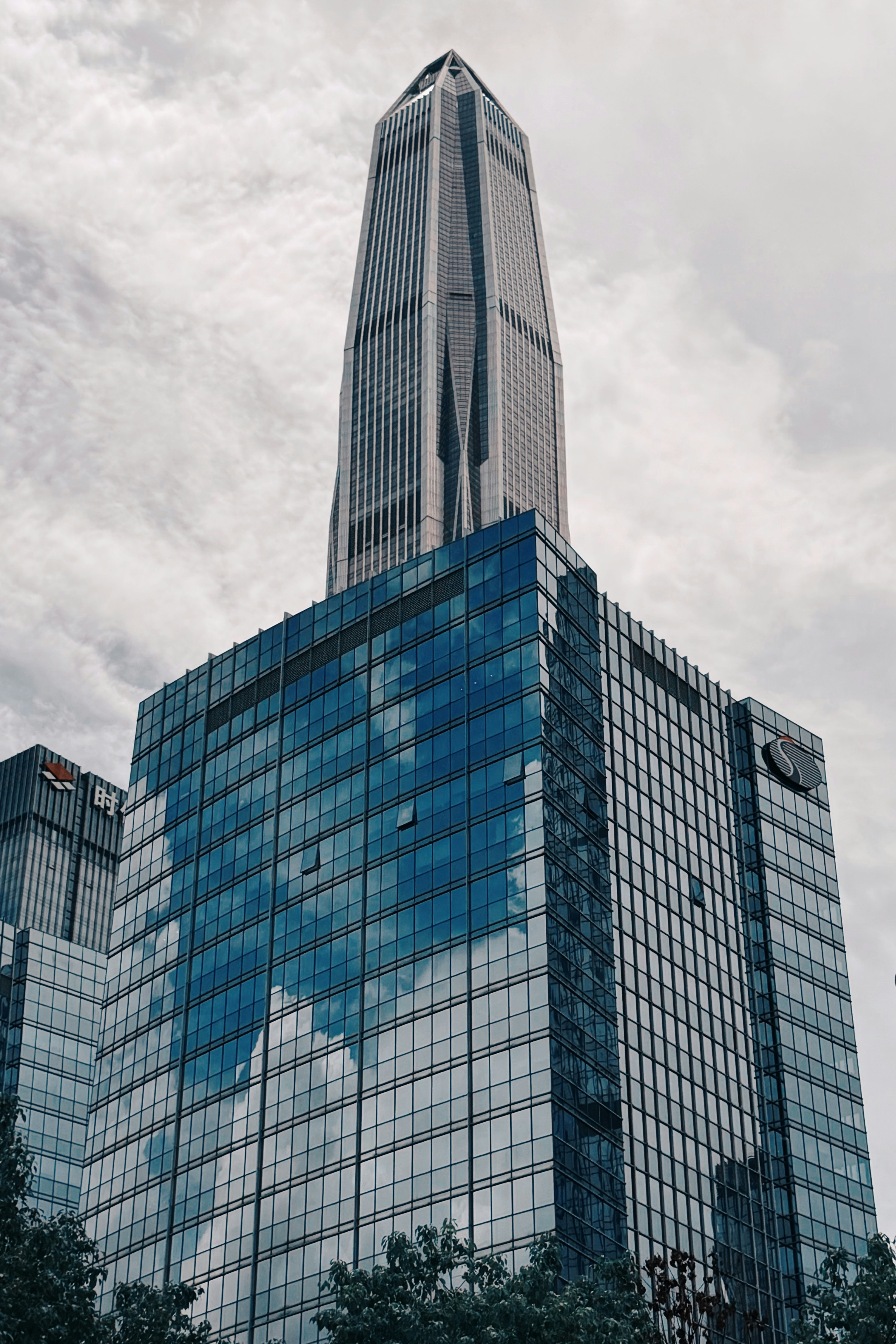 Vertical ascent: a glass-clad tower piercing a cloudy skyline