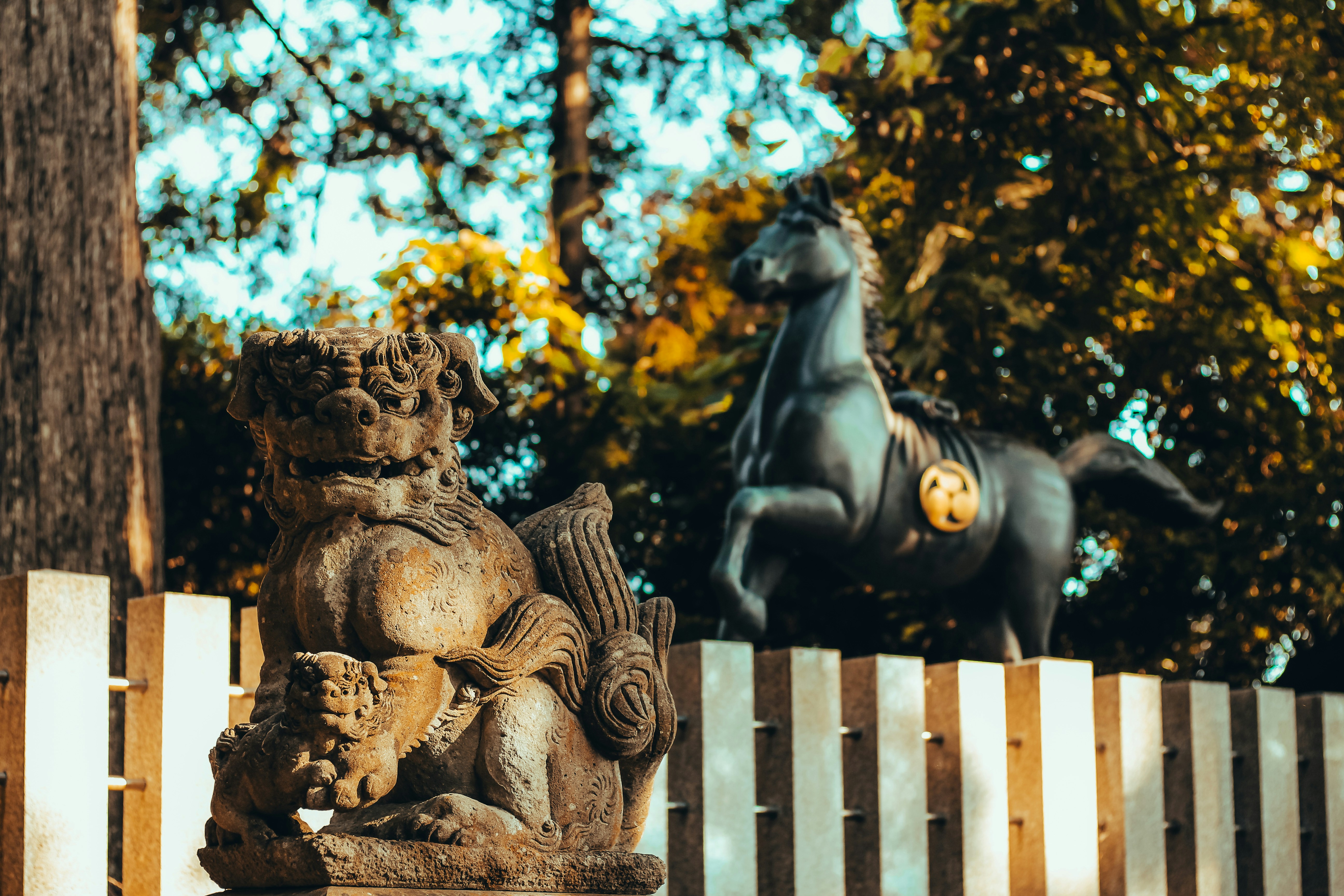 Stone Guardian by the Fence: Ancient Sculpture with a Stallion Shadow