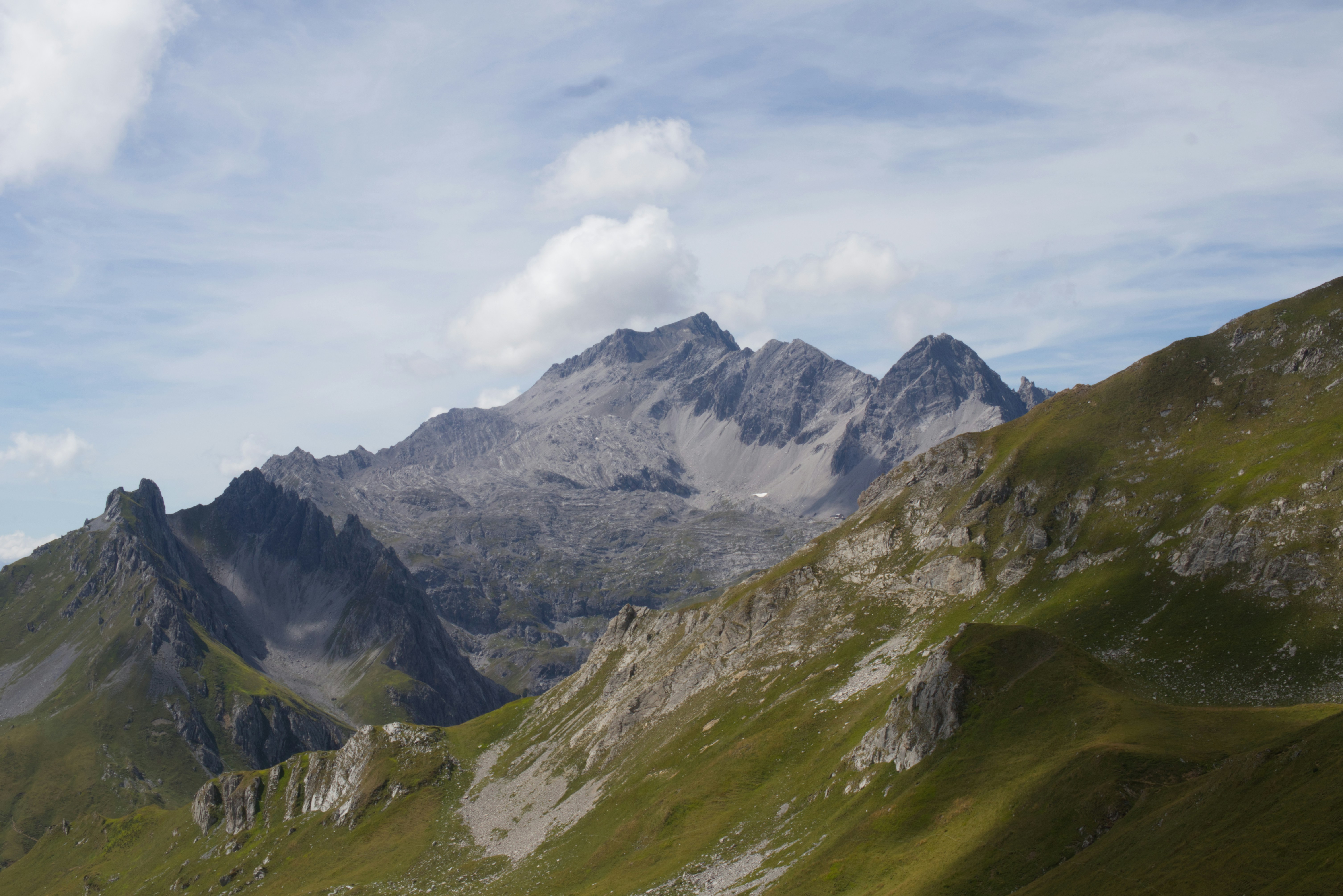 Rugged Alpine Crest: Sunlit Ridge Above the Green Slope