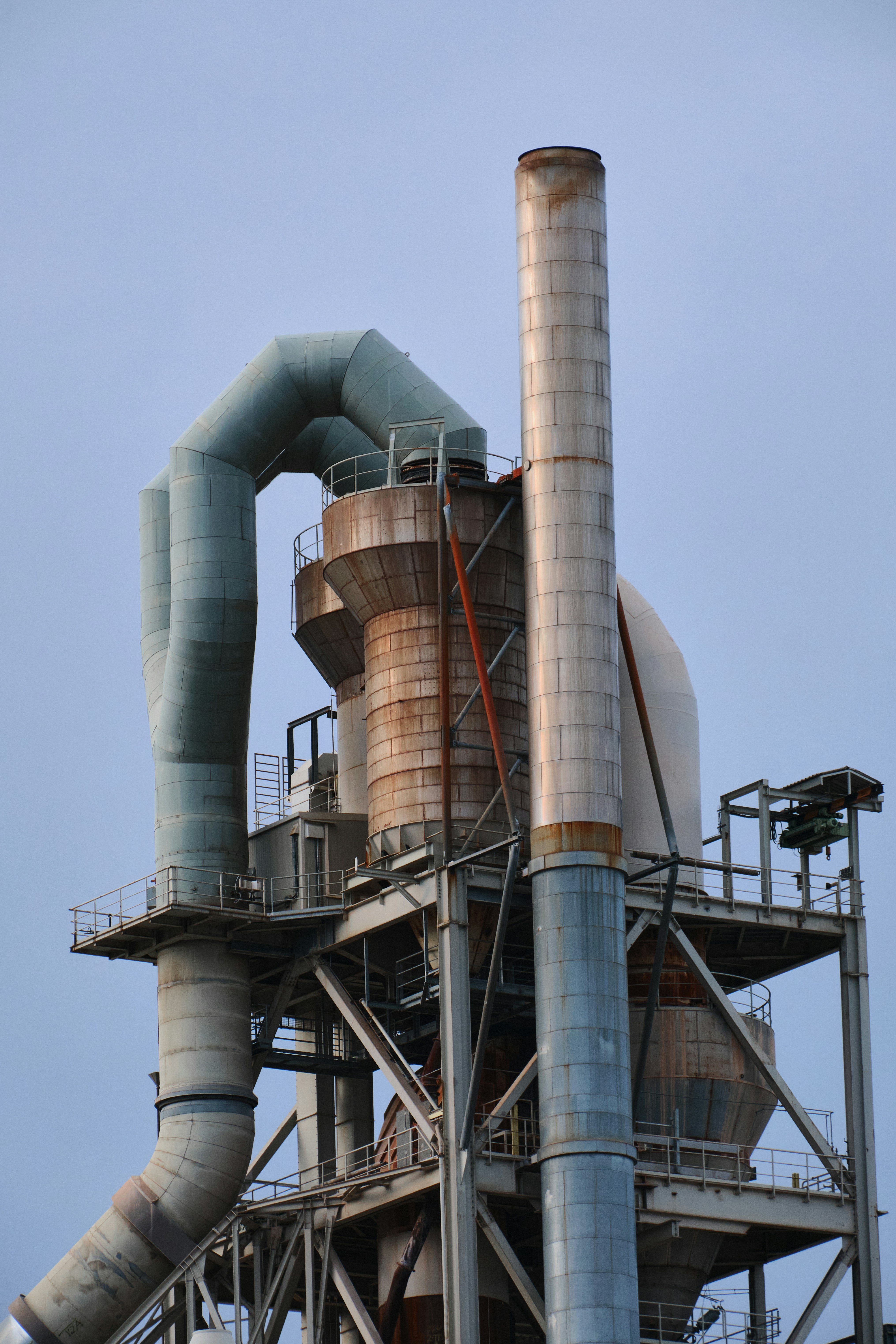 Industrial Skybound: Rust and Steel Arches Under a Clear Blue