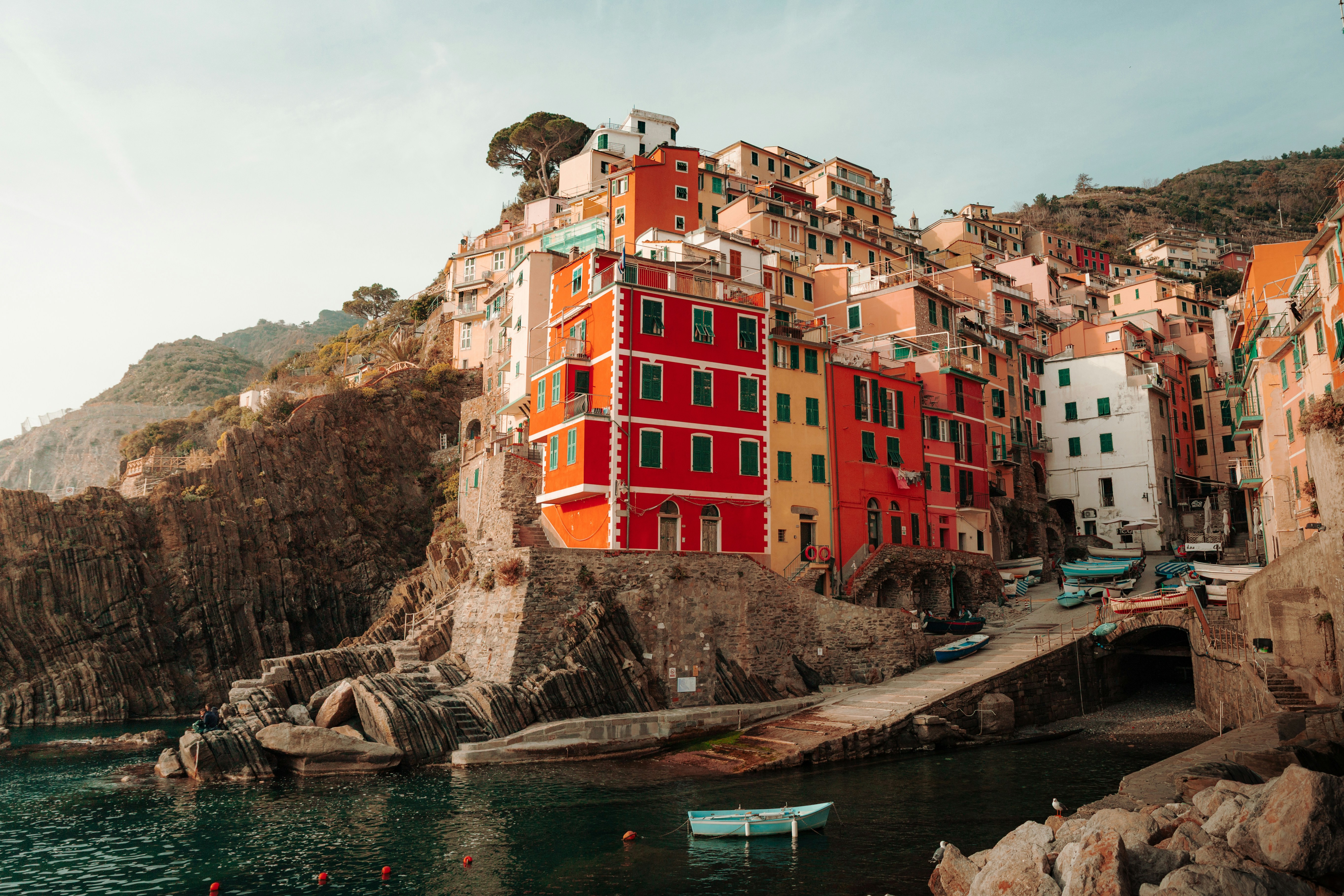 Vibrant cliffside village stacked in a sunlit Italian harbor