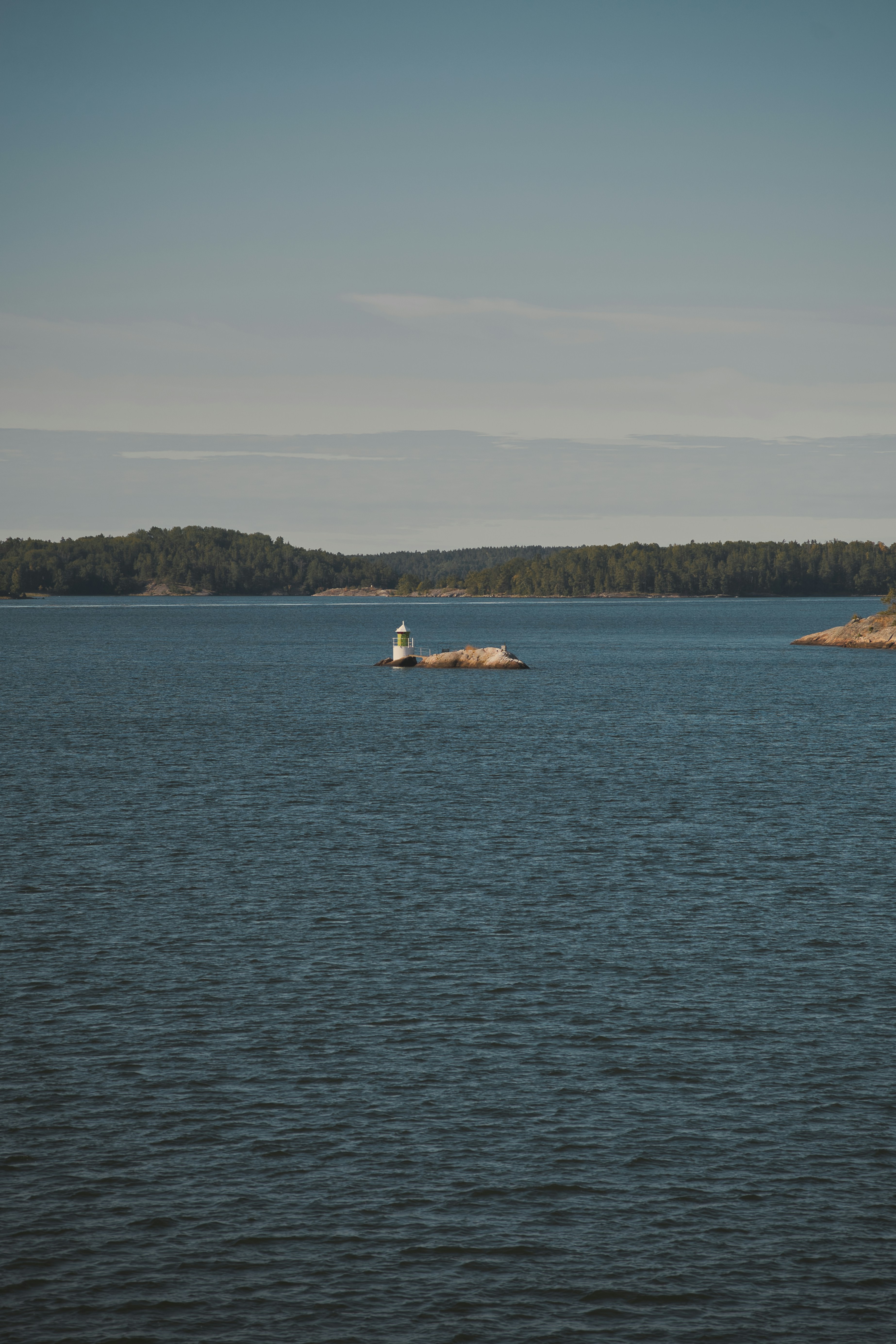 Lone Lighthouse on a Quiet Blue Horizon
