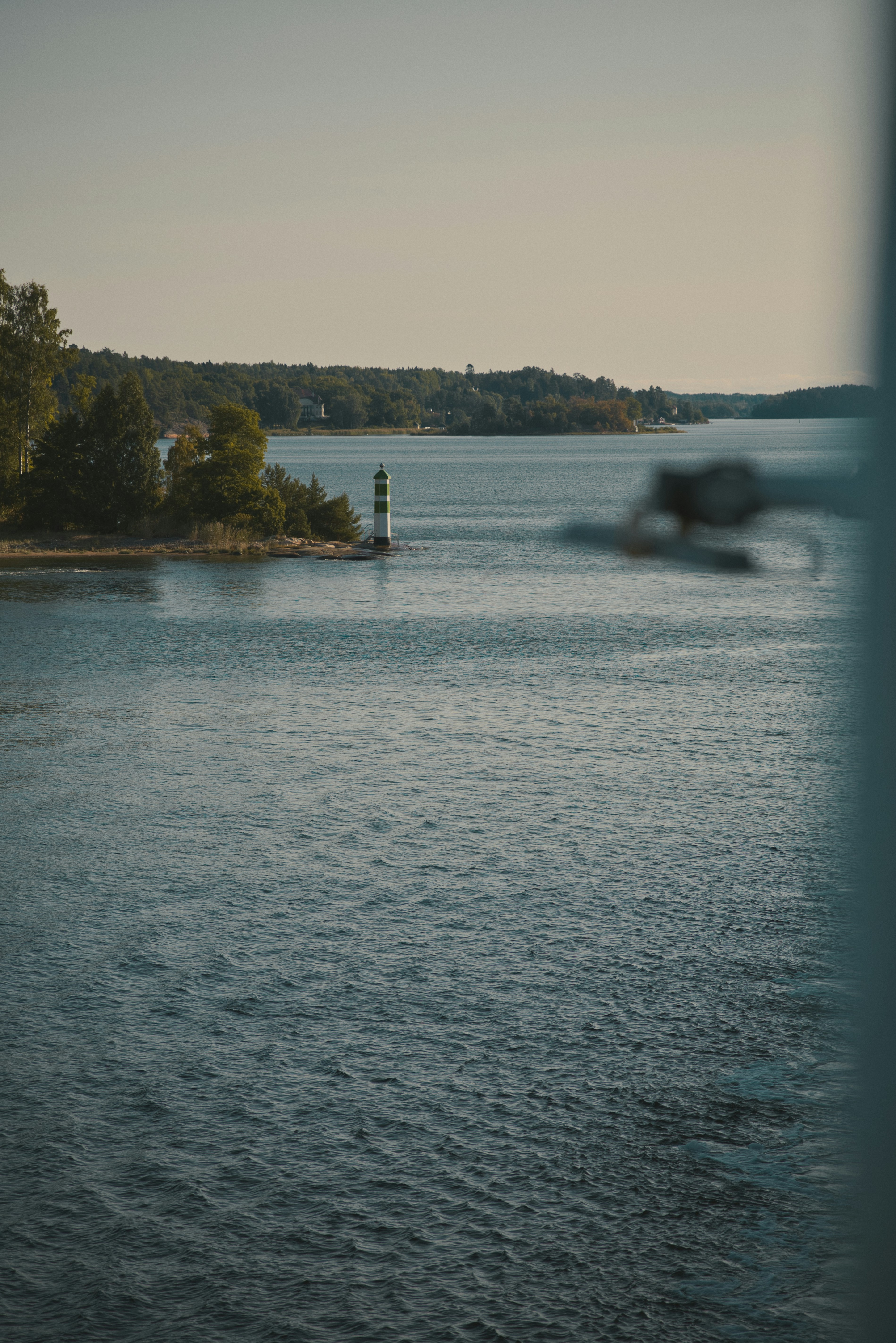 Lighthouse Sentinel at Dusk Across Quiet Waters
