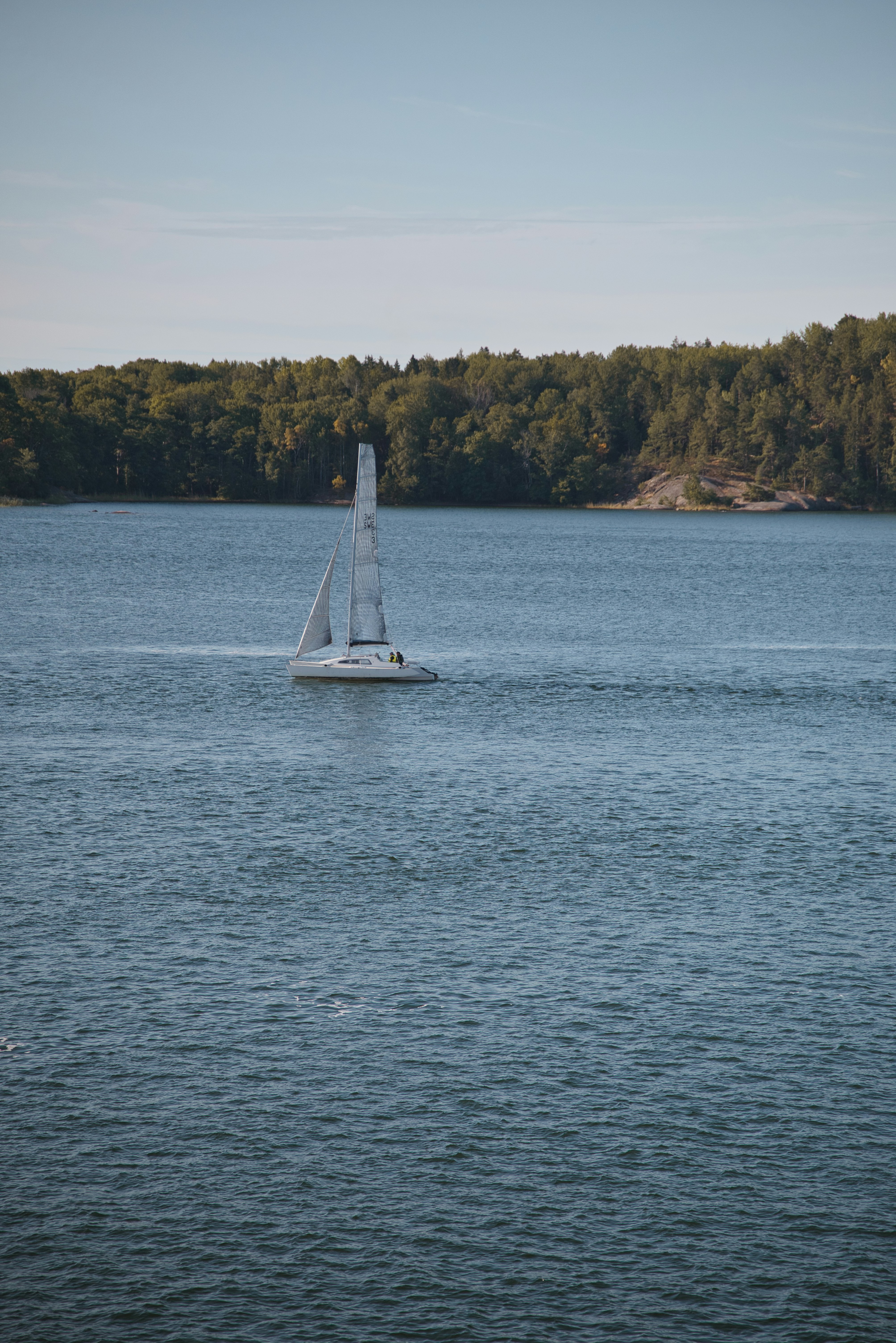 Sailboat Tranquility: Lone Vessel on a Quiet Lake