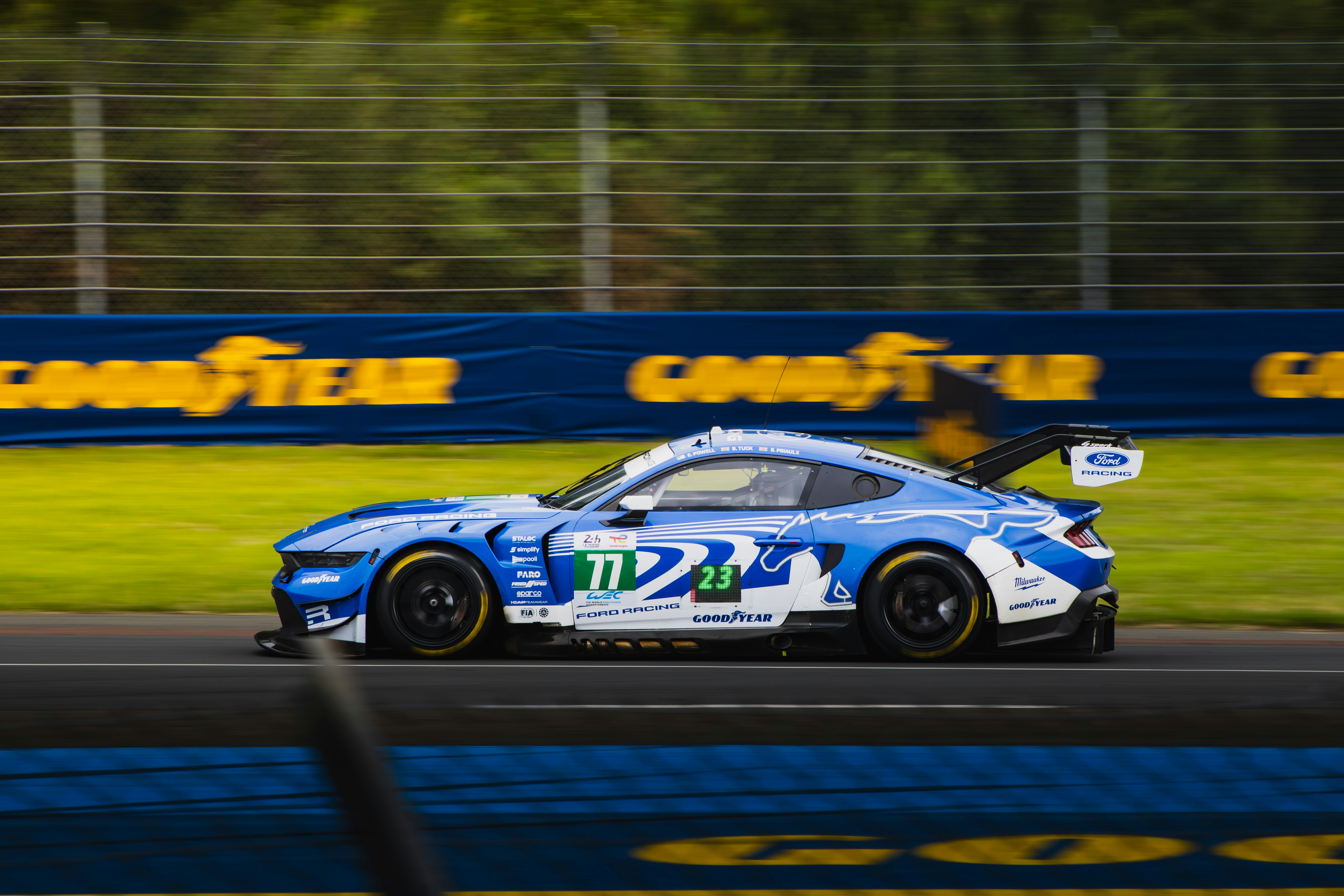 Blue racer in motion: a focused sprint along the track