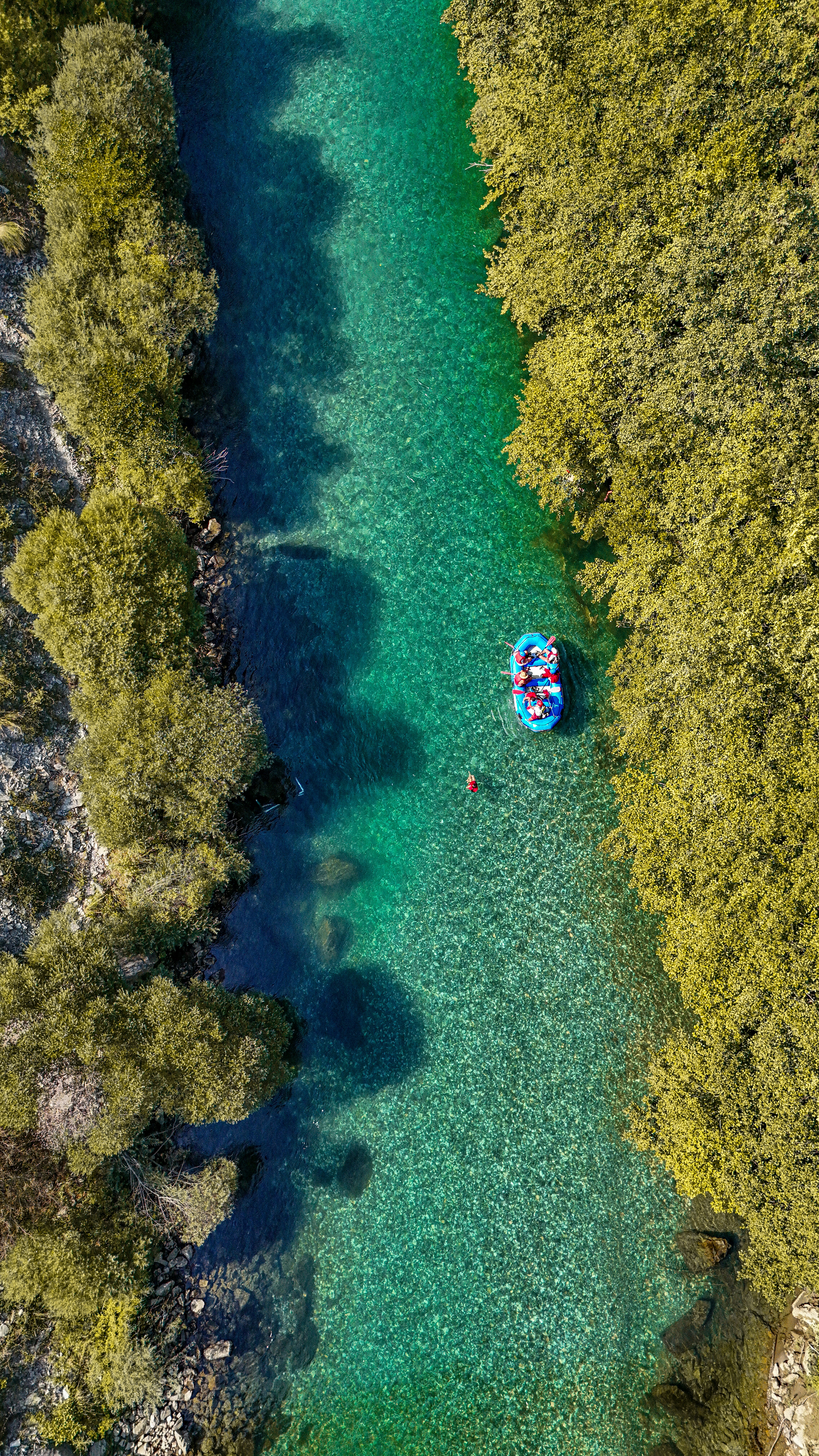 Emerald River Run: A Boat and Its Red-Capped Traveler