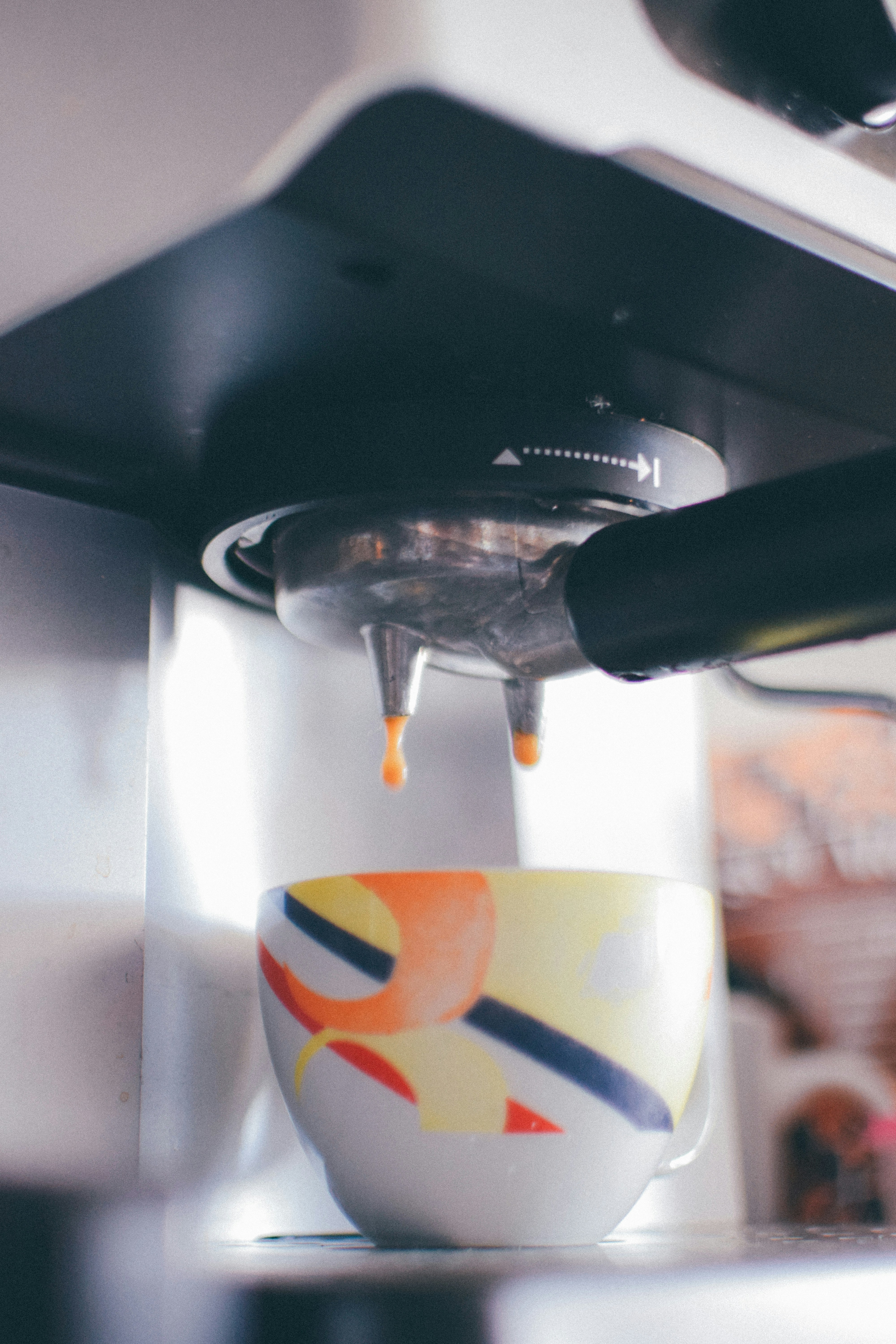 Caffeinated Focus: Espresso Drops from the Machine Nuzzle a Cerulean Cup