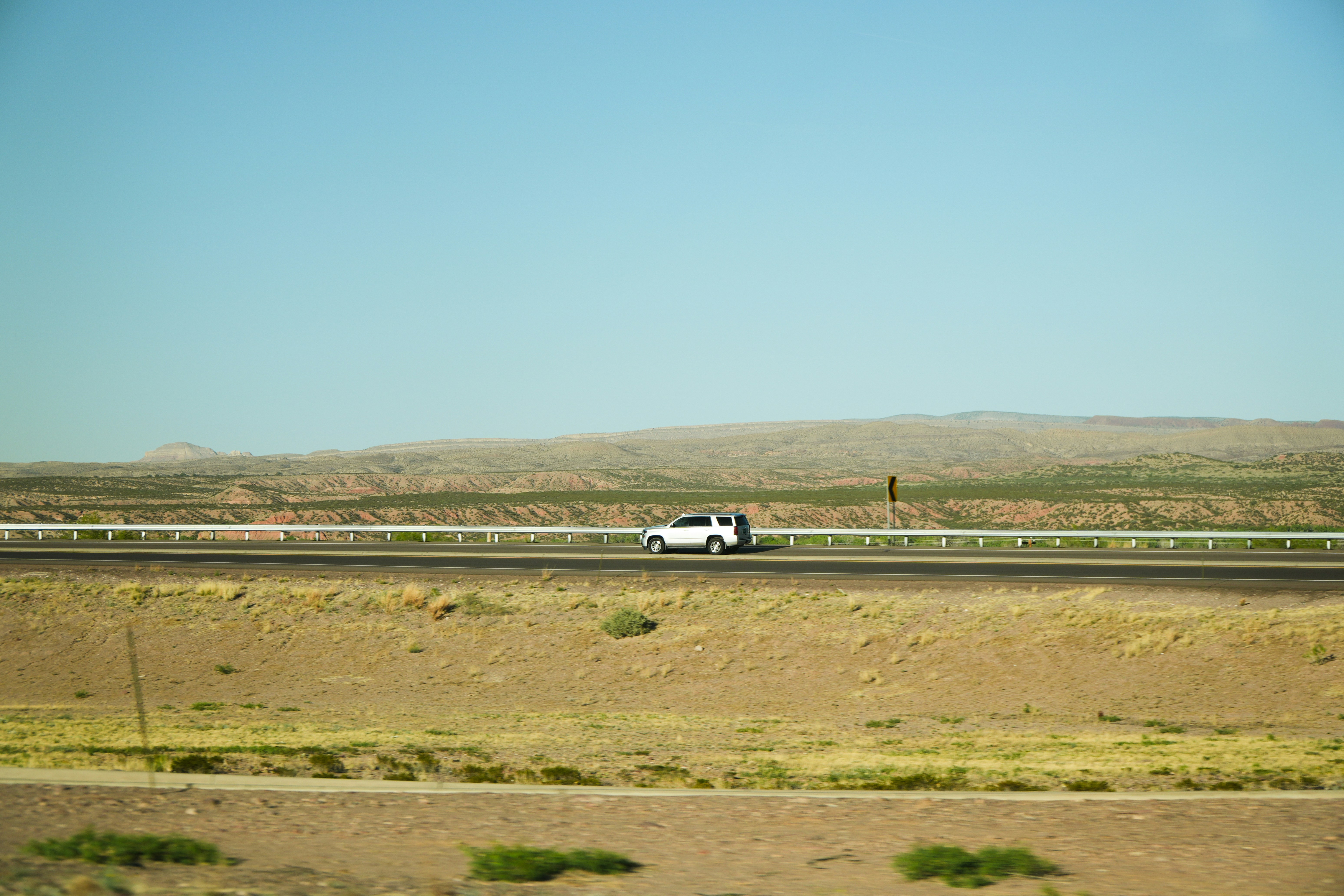 Highway Quiet: A White Pickup Traverses a Desert Viaduct