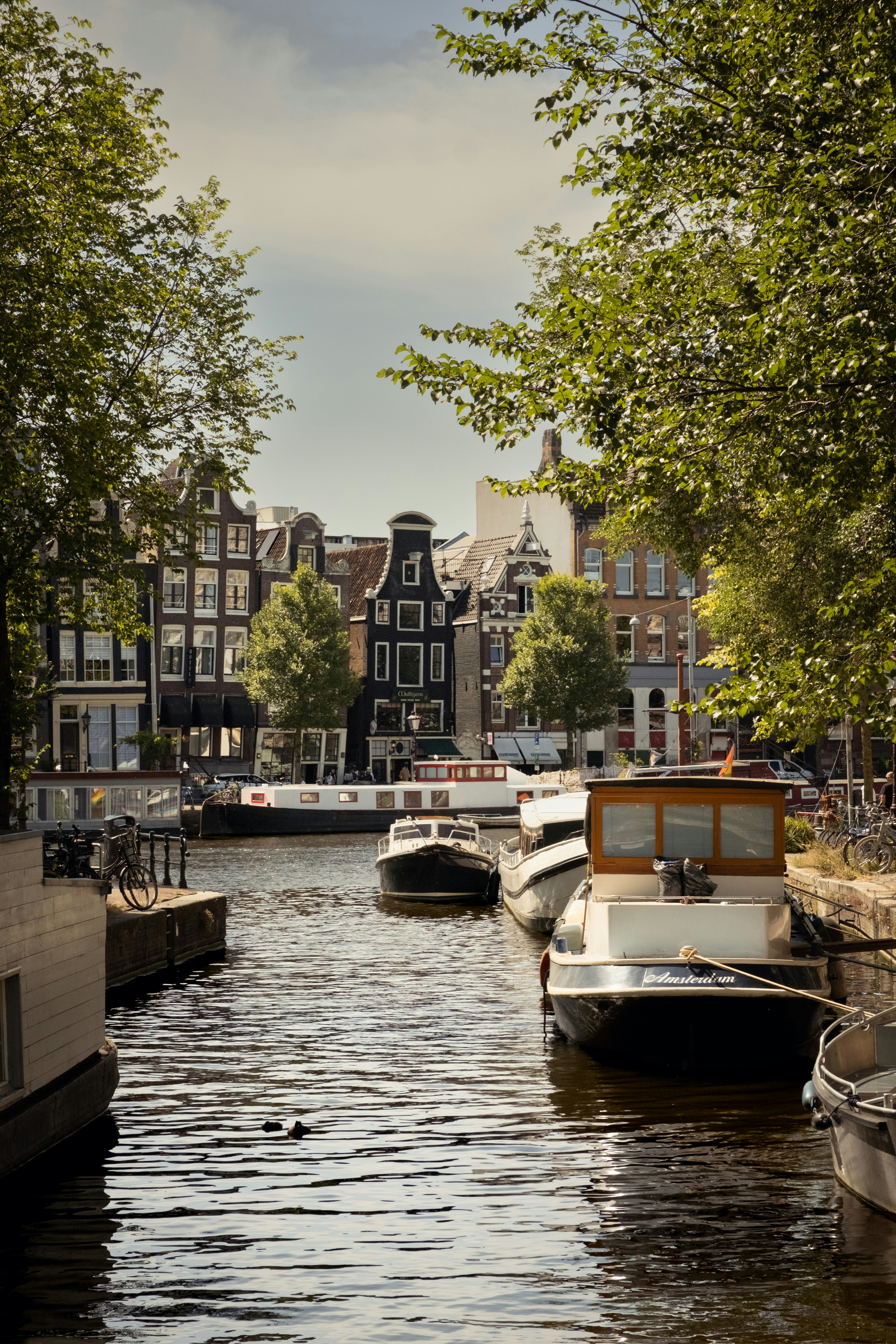 Canal of Quiet Motion: Boats Rest Along a Sunlit Amsterdam-esque Channel