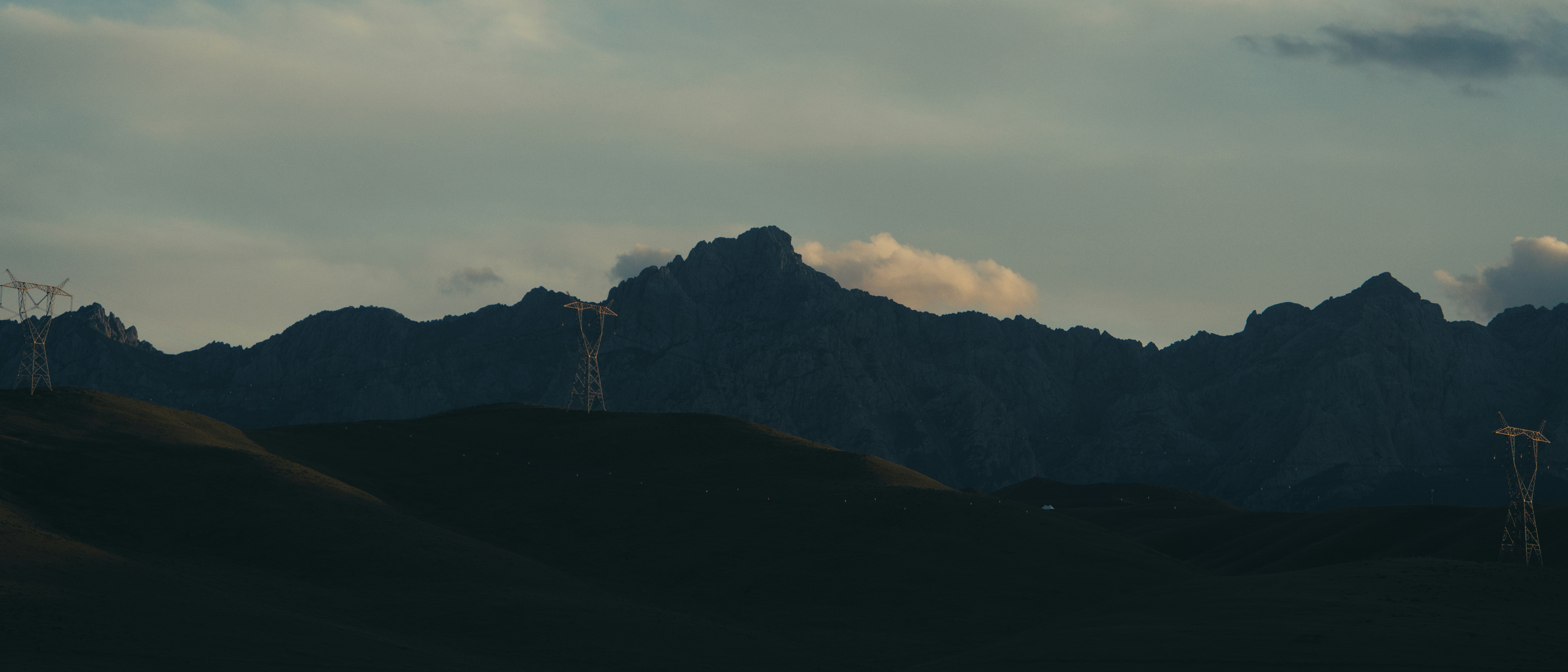 Distant Peaks Beneath Quiet Power Lines at Dusk