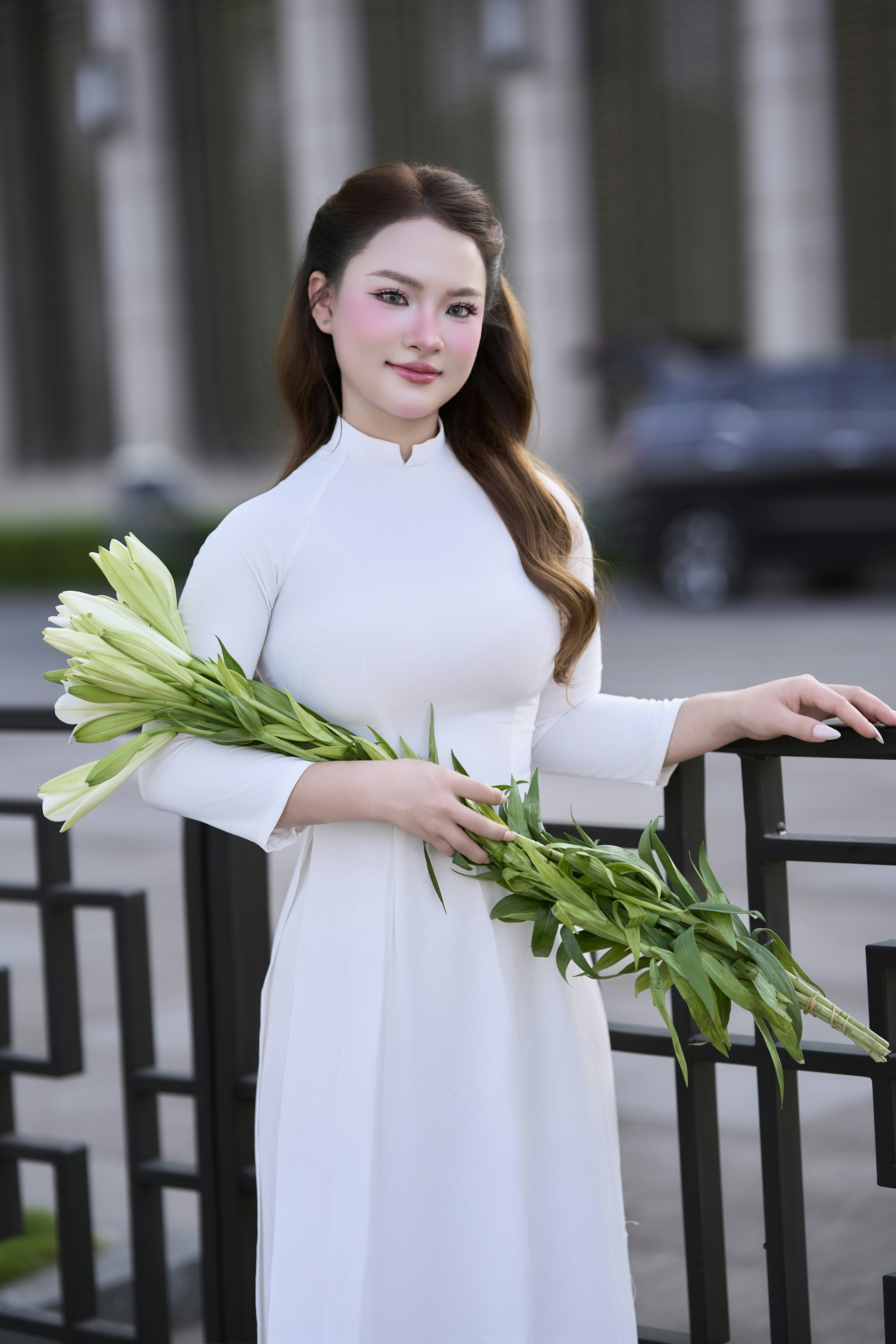 White dress, green bouquet, and a quiet gaze by the railing