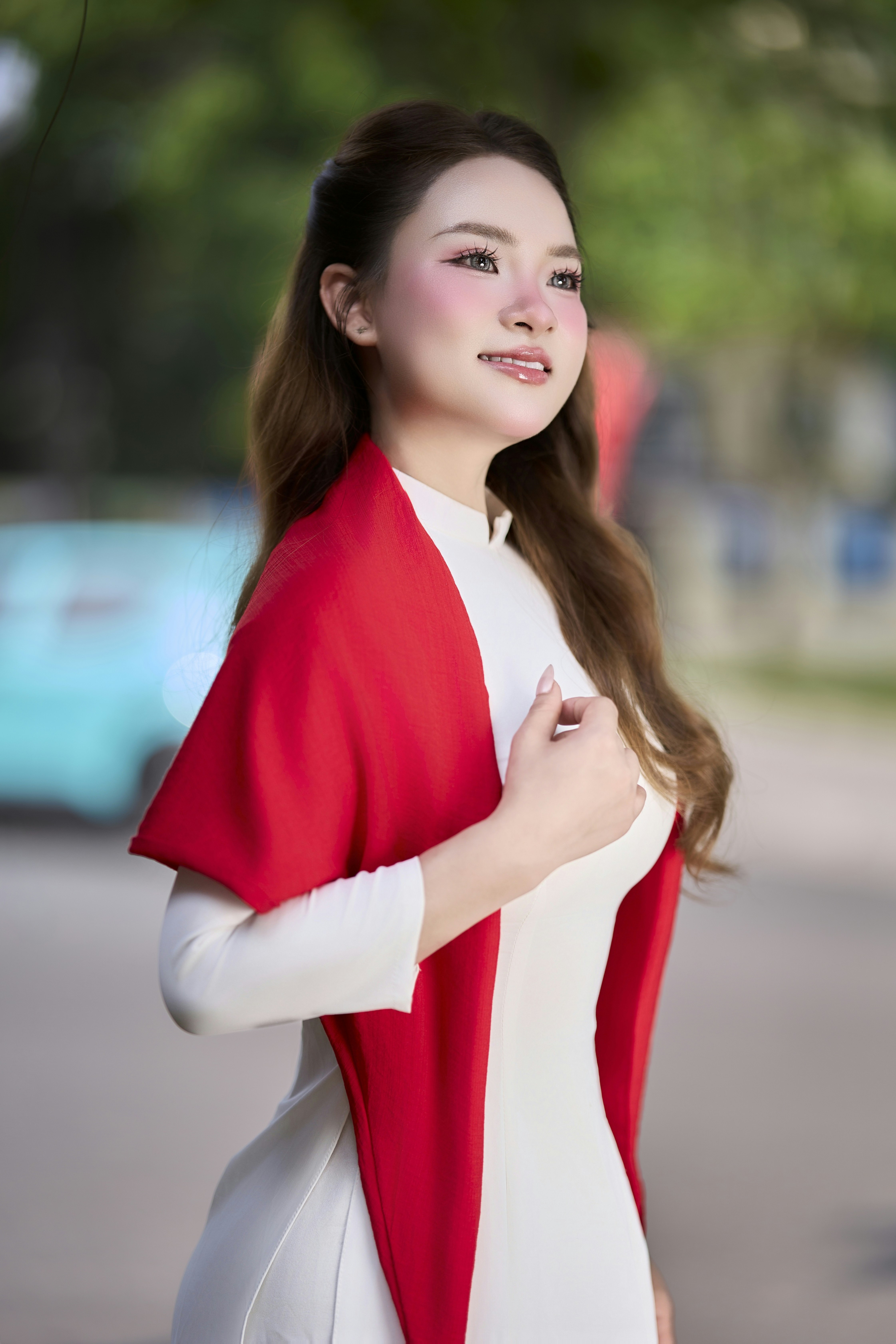 Grace in Red: Portrait of Confidence Against a Blurred Avenue