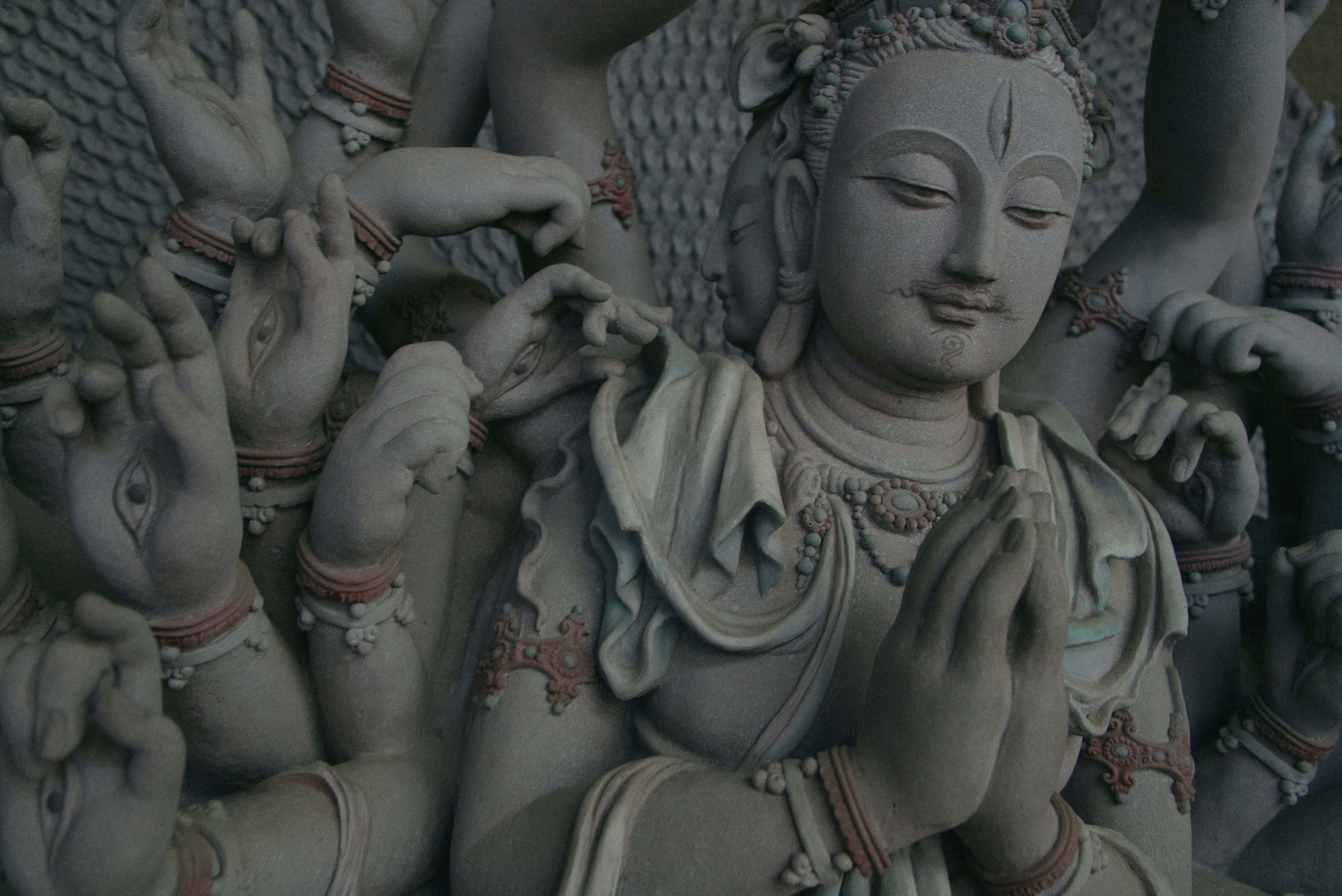 Calm Reverence: A Multi-Armed Statue in Subtle Light