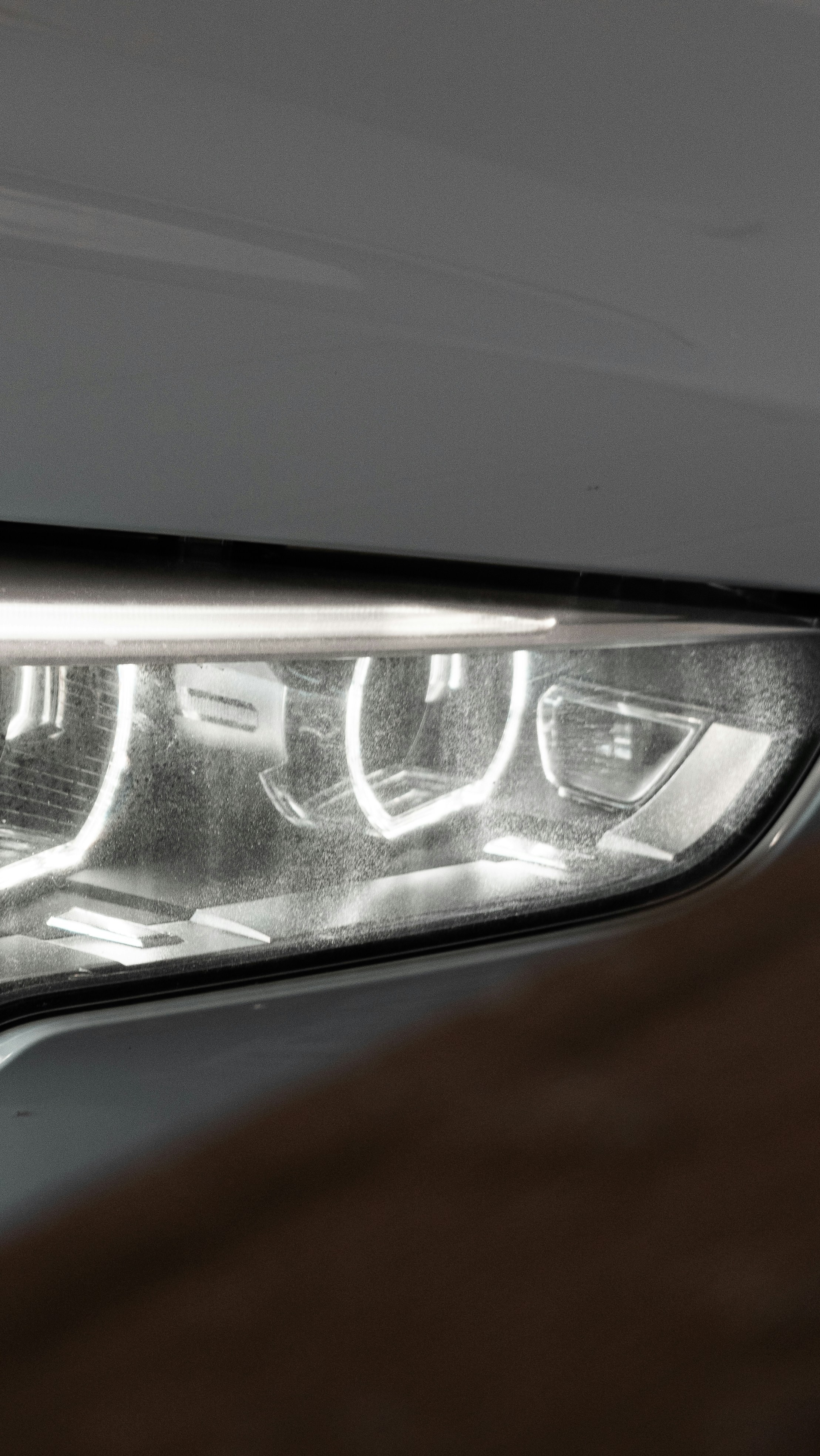 Close-up of an automotive headlight amid sleek bodywork