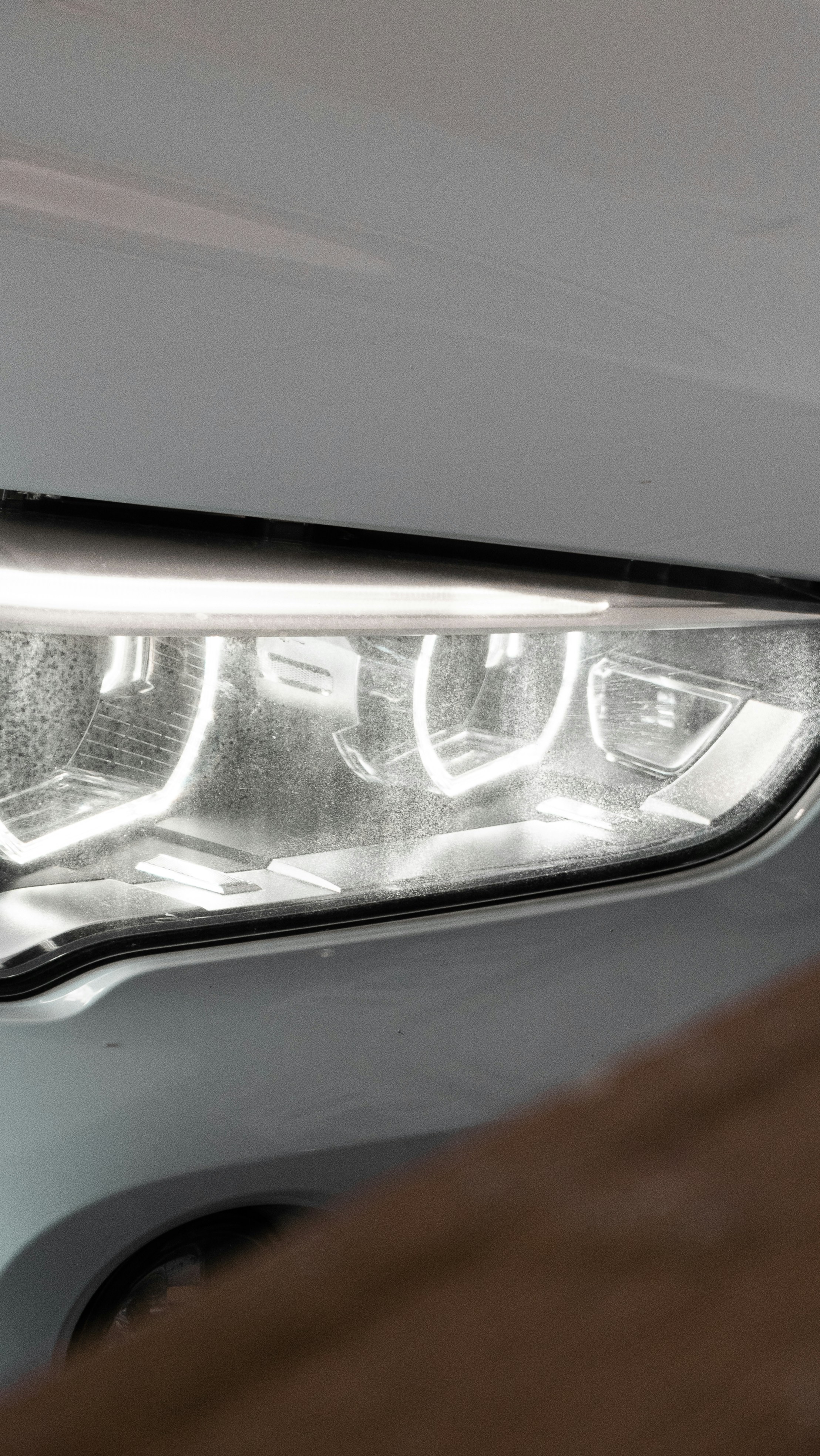 Headlight Glimmer Through a Car Hood in Soft Street Light