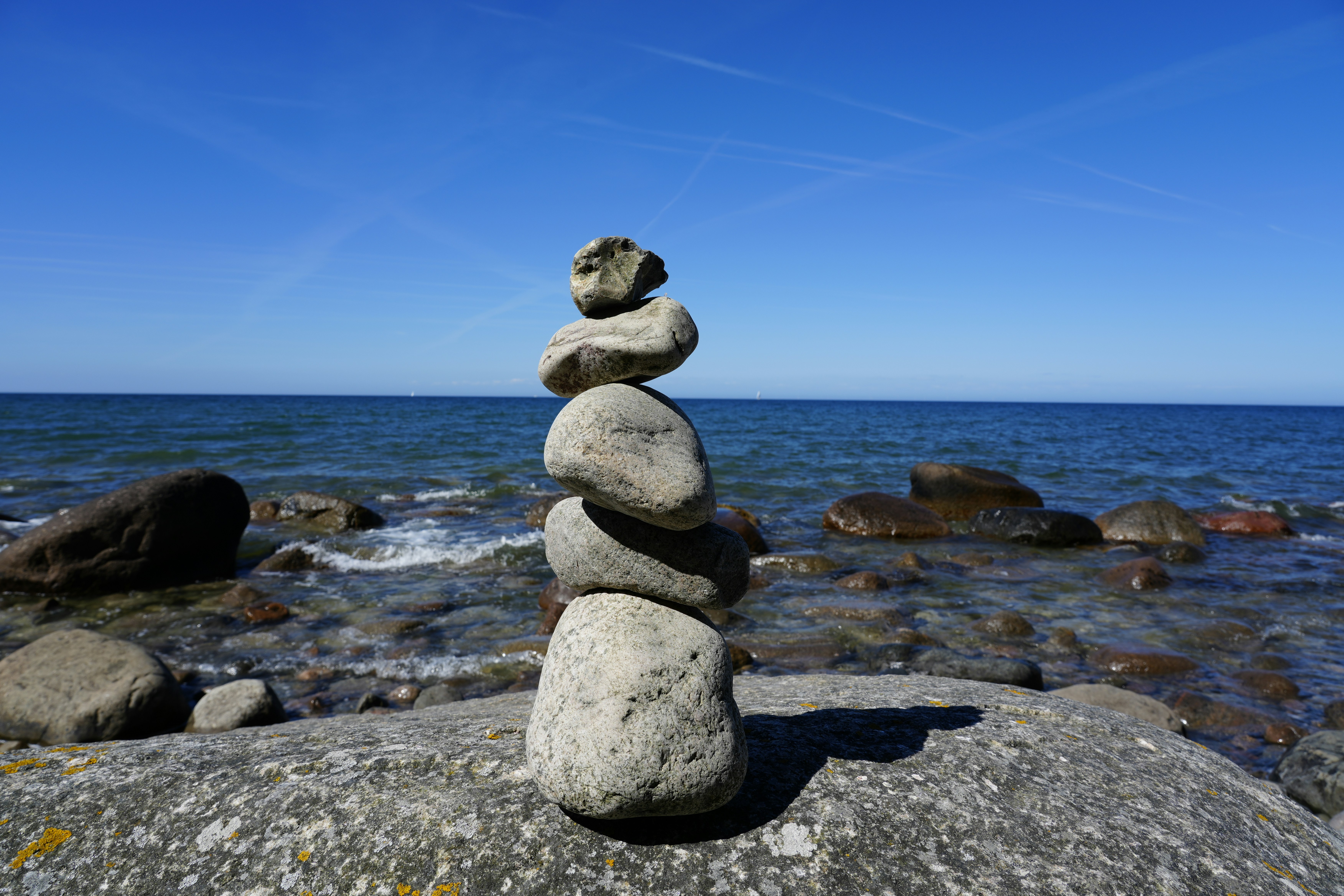 Balanced Pebble Tower at a Sunlit Shore