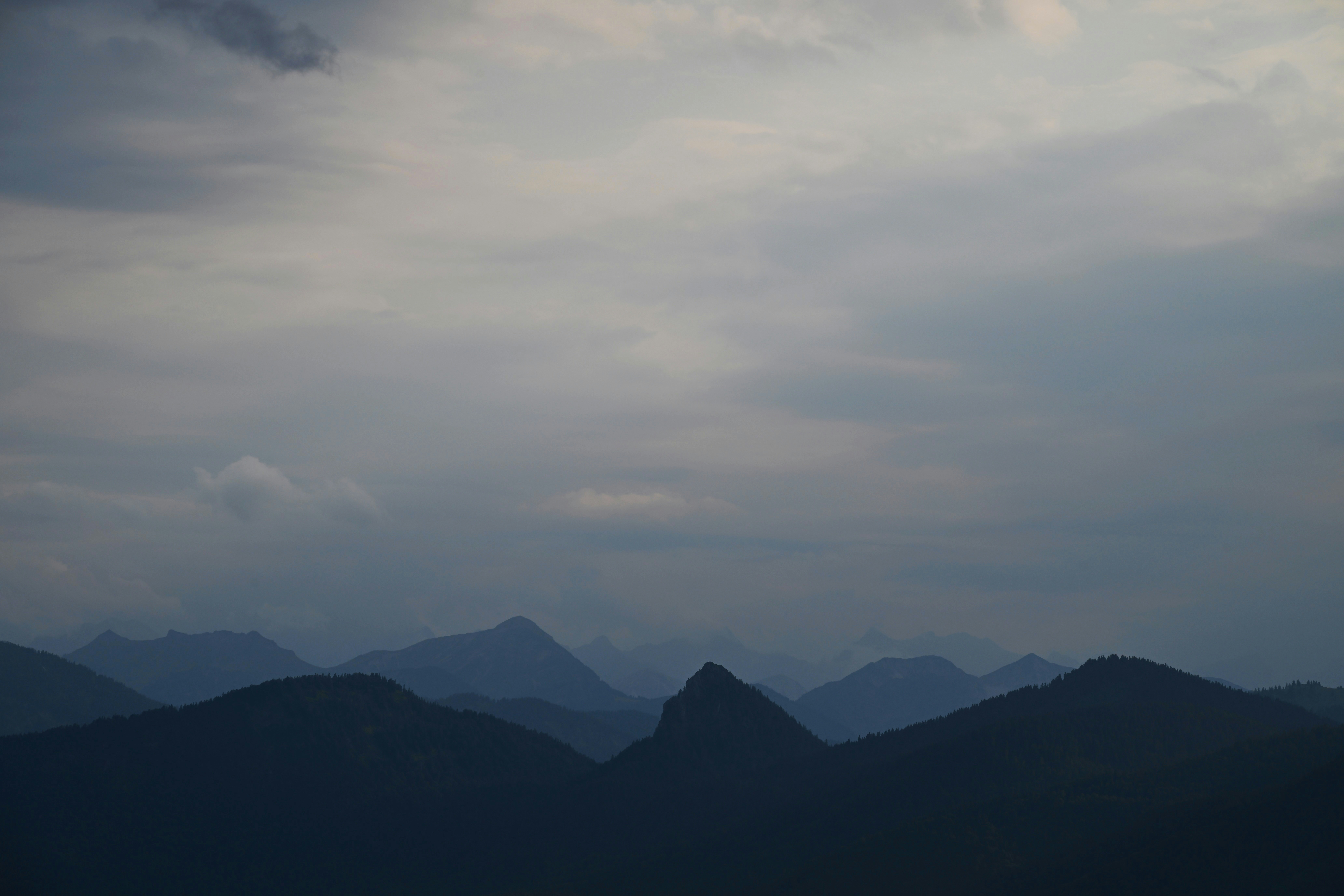 Layered Dusk: Silhouetted Peaks Beneath a Quiet Sky