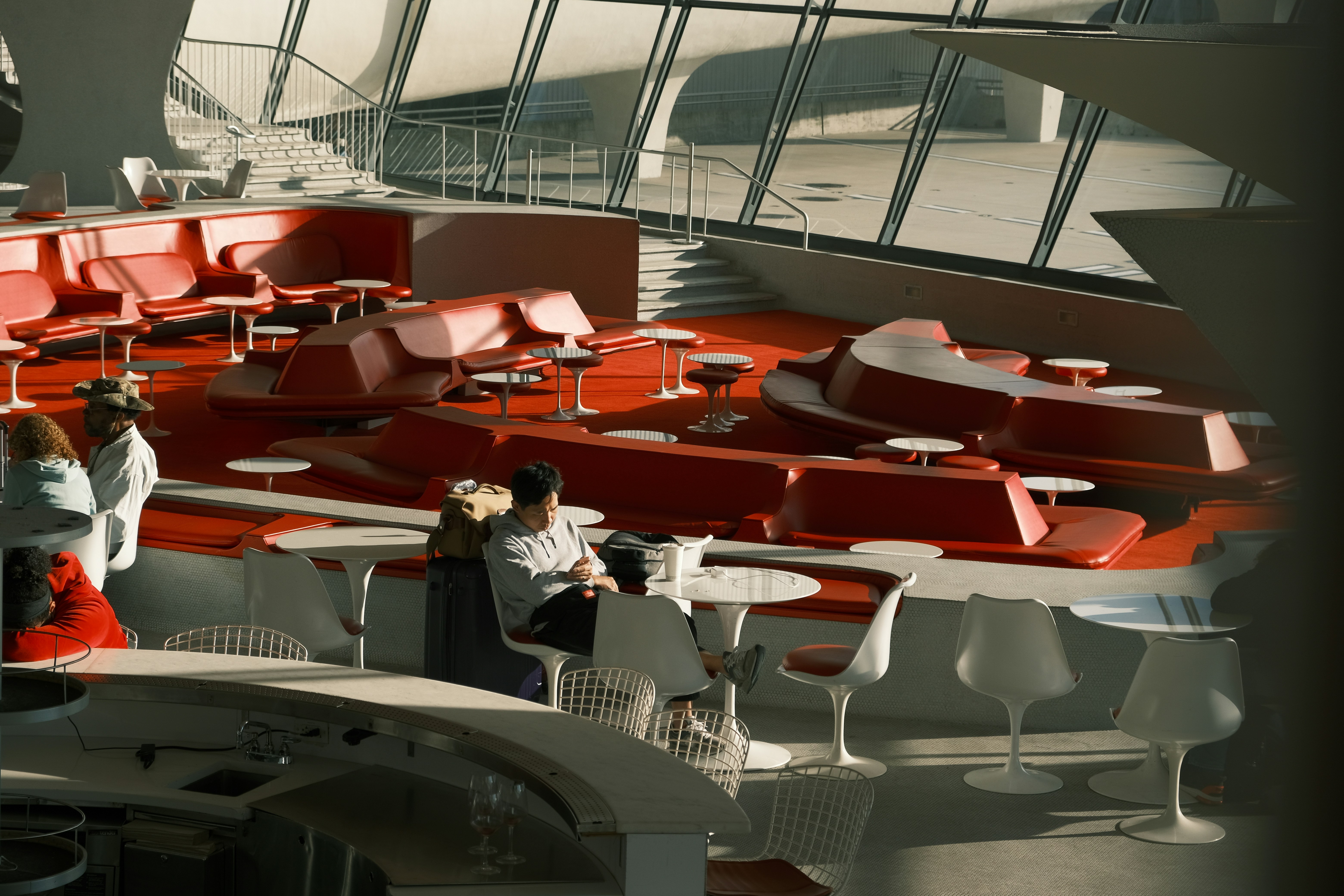 Quiet Assembly: A Couple in Conversation Among Red Lounge Rhythm