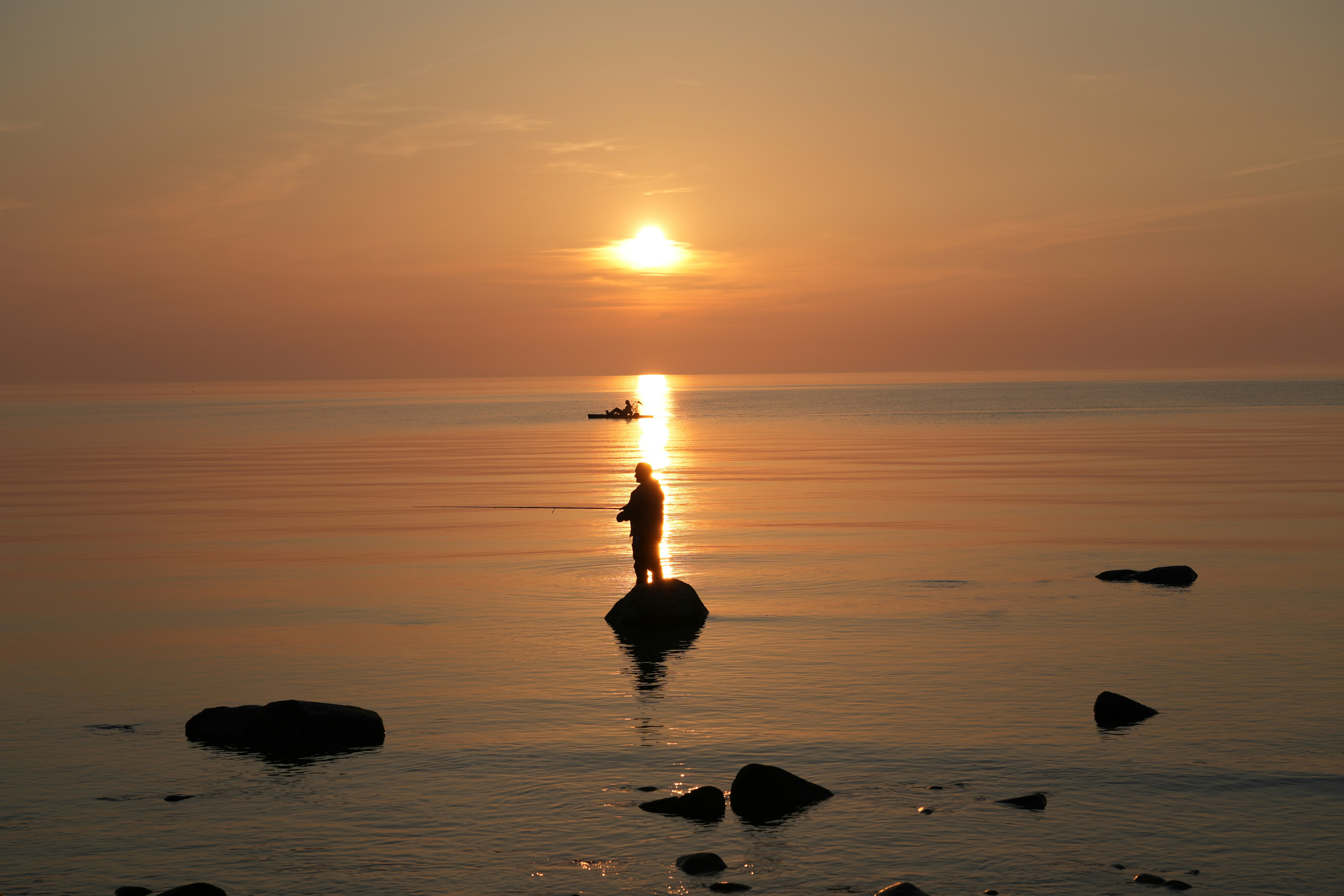 Solitary Fisherman at Sunset: A Quiet Moment on the Tidal Mirror