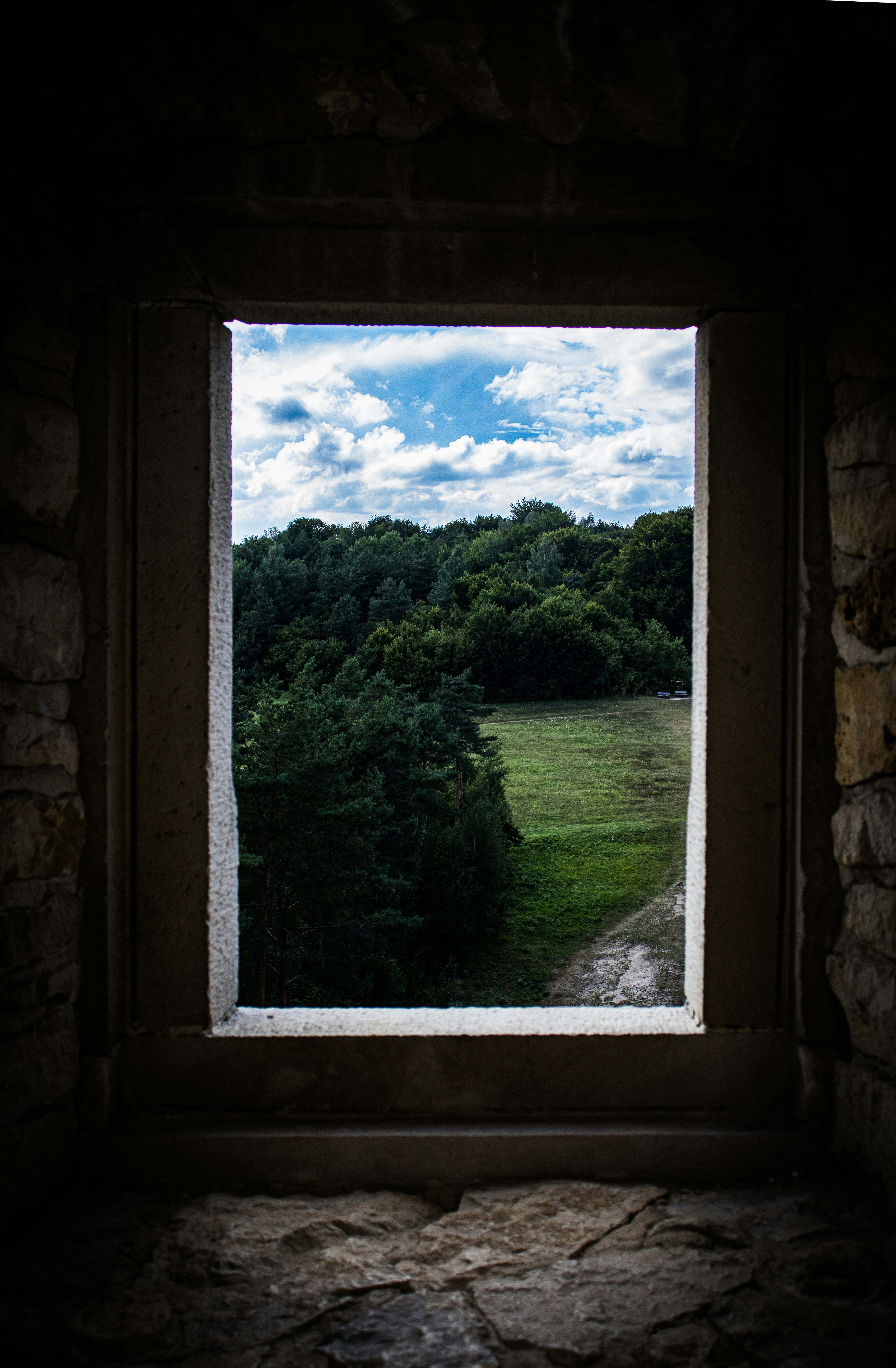Quiet Portal: A View Through Stone Walls to an Open Green Field