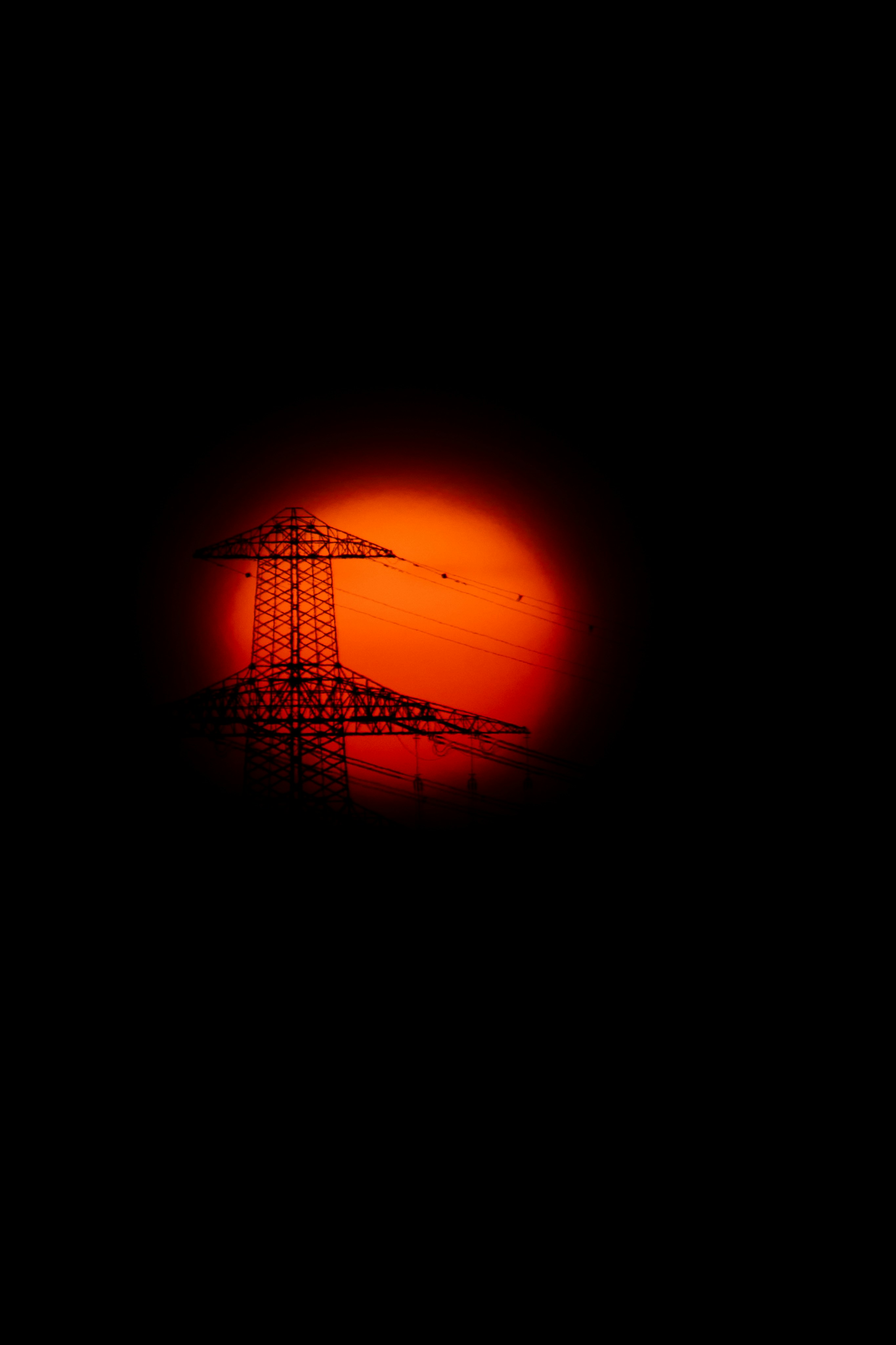 Sunset Spark: A Silhouette of Power Lines Against a Fiery Orbs
